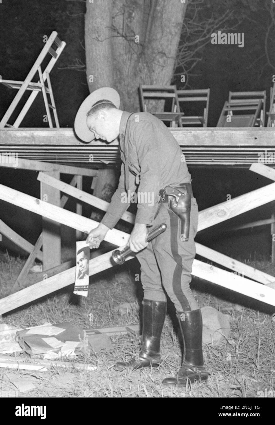New York State Trooper J. P. Christian picks up a torn picture of black ...