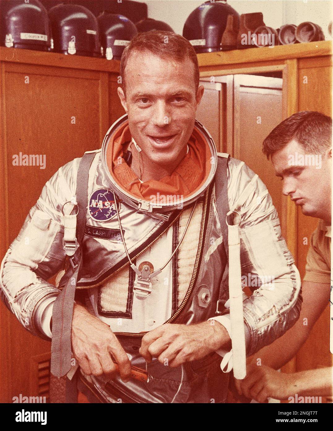 Astronaut Scott Carpenter has his space suit adjusted by a technician ...