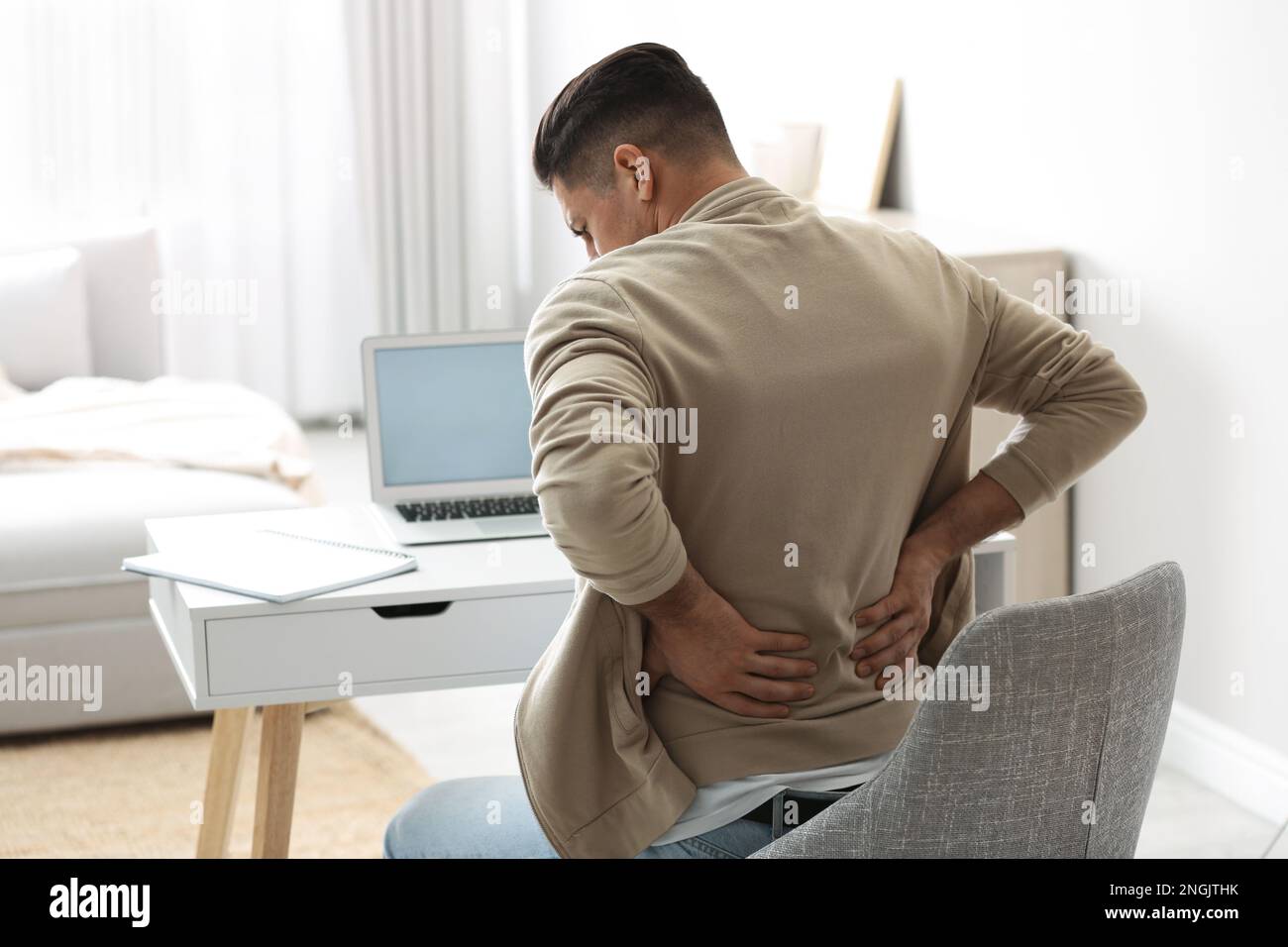 Man suffering from back pain at workplace. Bad posture problem Stock ...