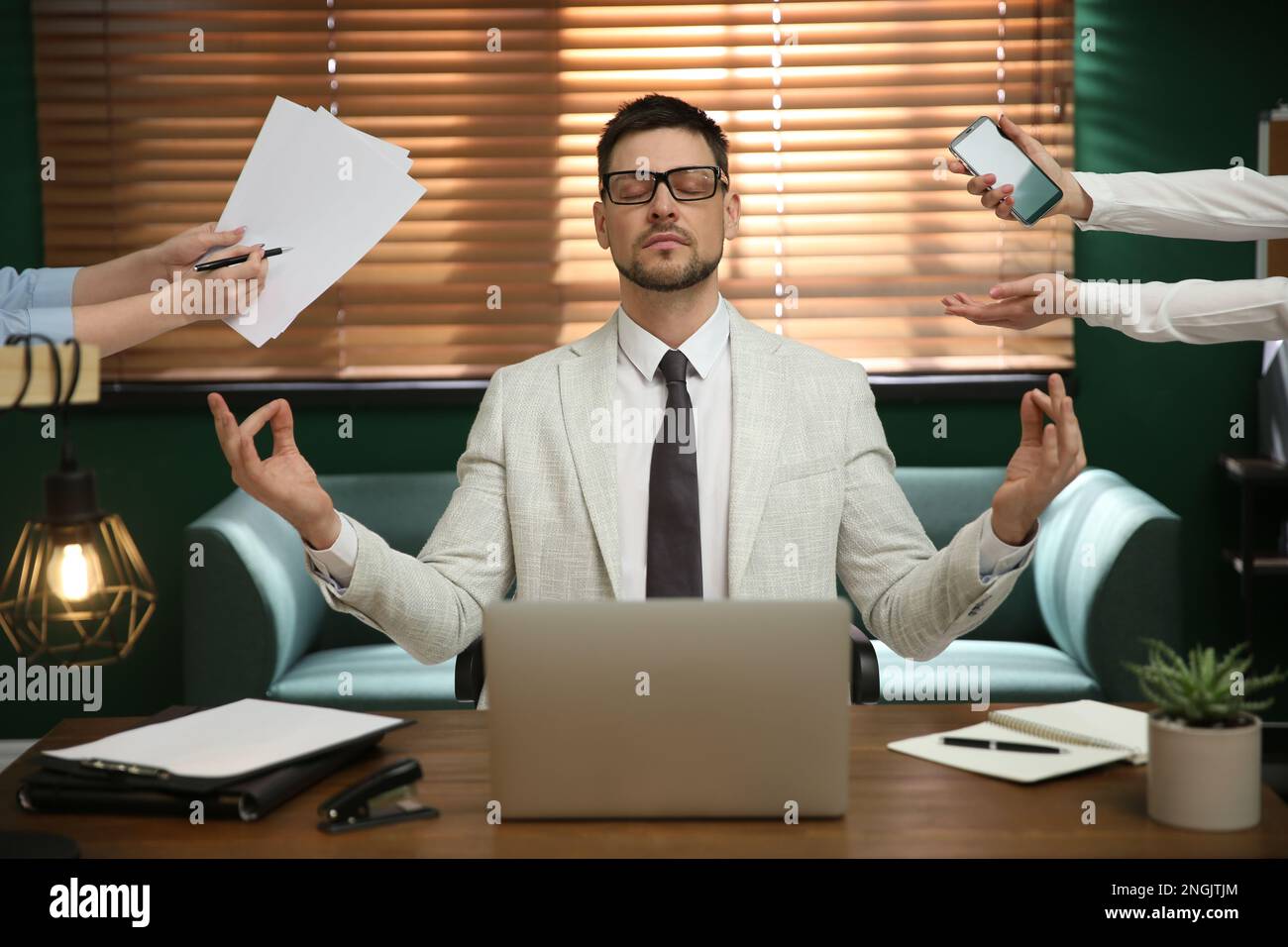 Calm businessman meditating at office desk in middle of busy work day Stock Photo - Alamy