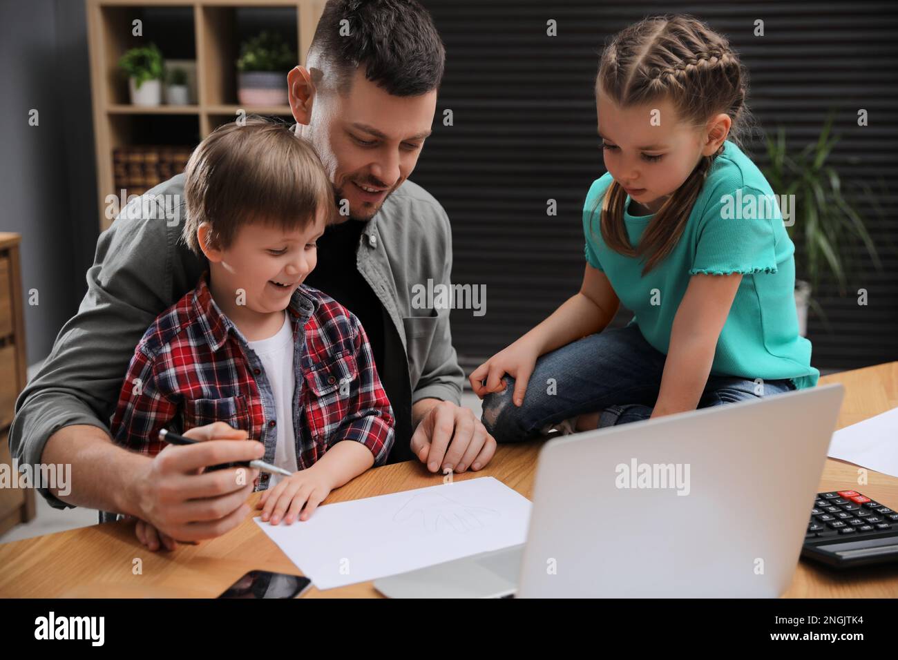 Happy man combining parenting and work at home Stock Photo - Alamy