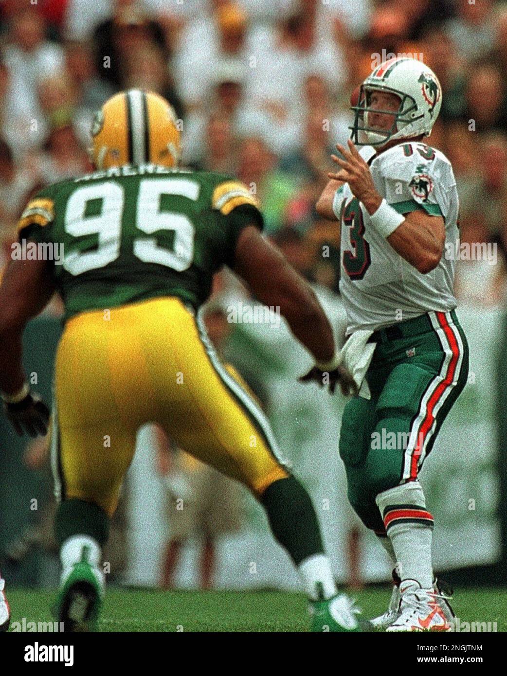 Miami Dolphins quarterback Dan Morino throws a pass while being rushed ...