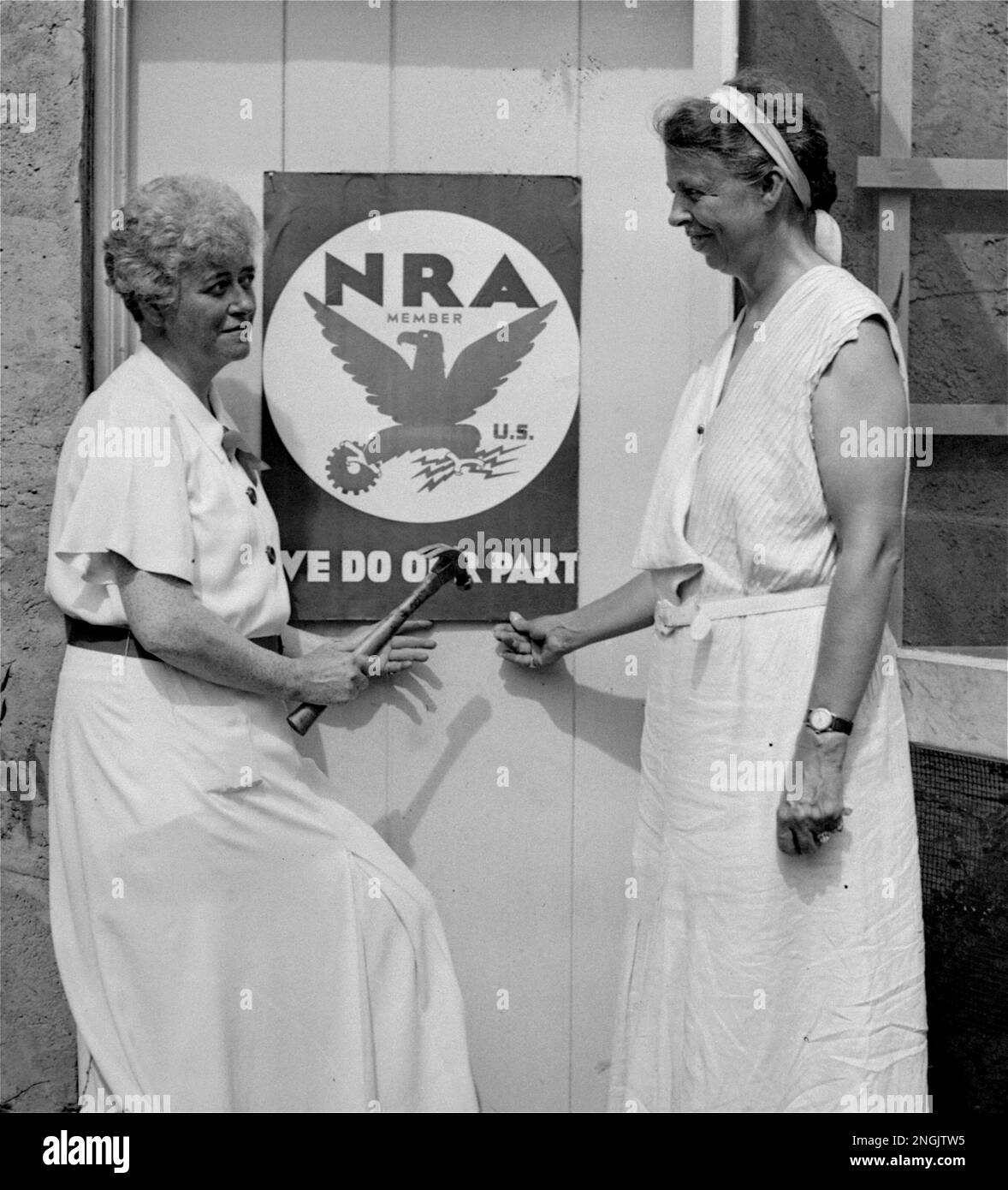 Miss Nancy Cook, left, and First Lady Eleanor Roosevelt, hang up an NRA ...