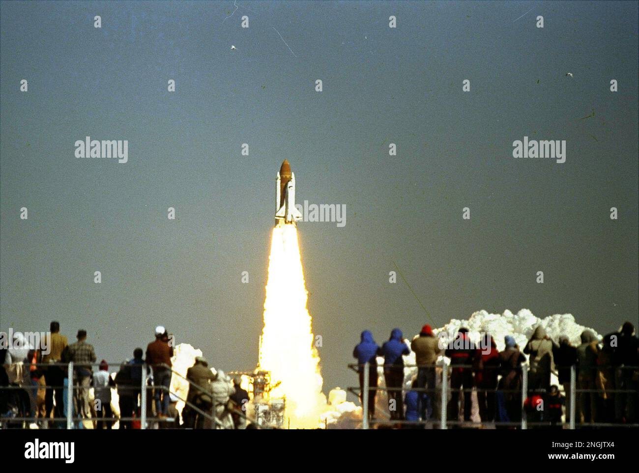 Spectators in the VIP area at the Kennedy Space Center, Fla., watch as ...
