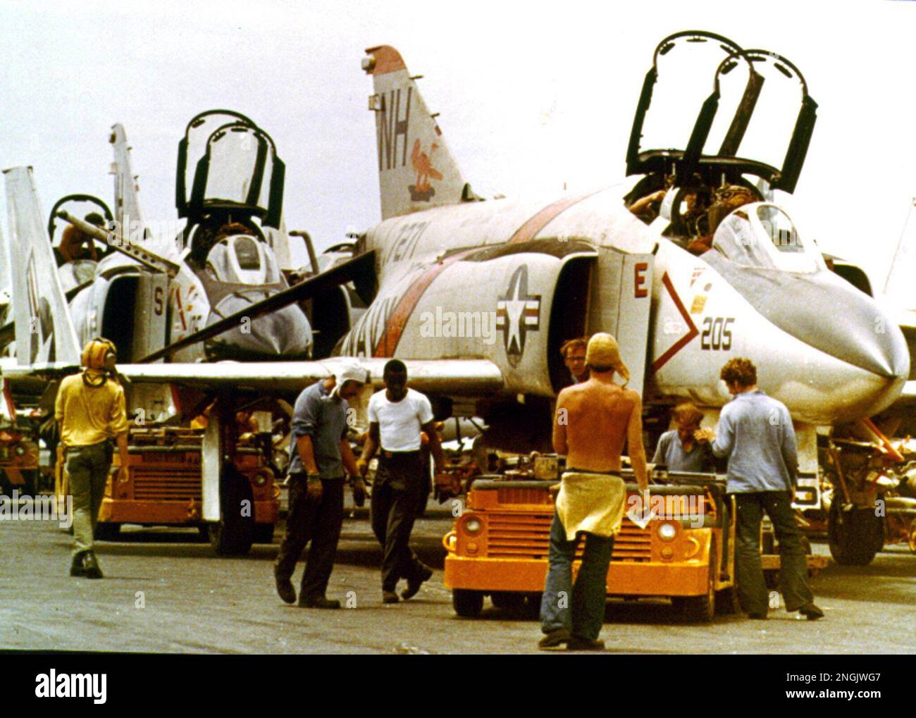 United States Navy crewmen bustle with strike aircraft on the deck of ...