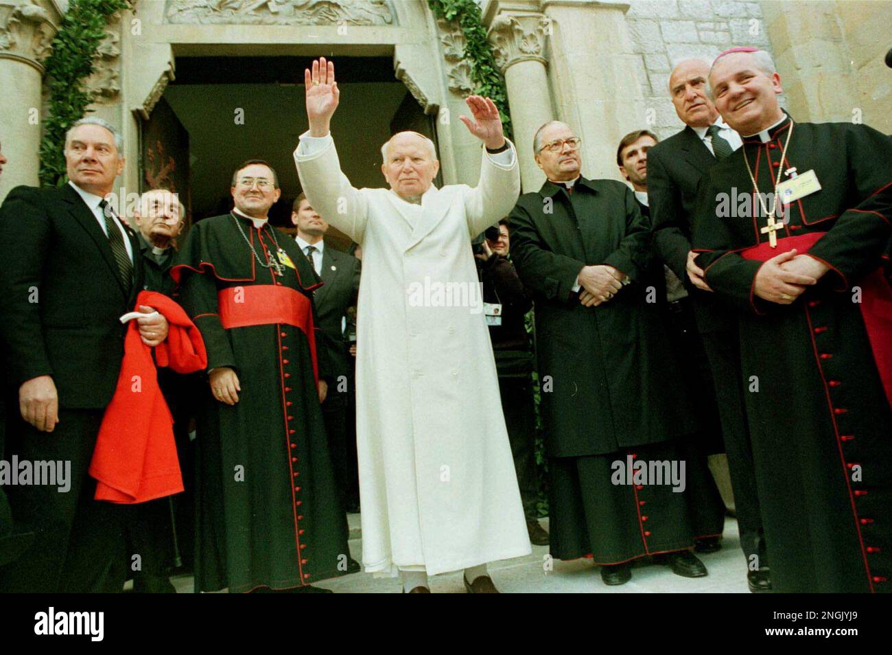 Pope John Paul II, flanked by clergymen, blesses the crowd from the ...