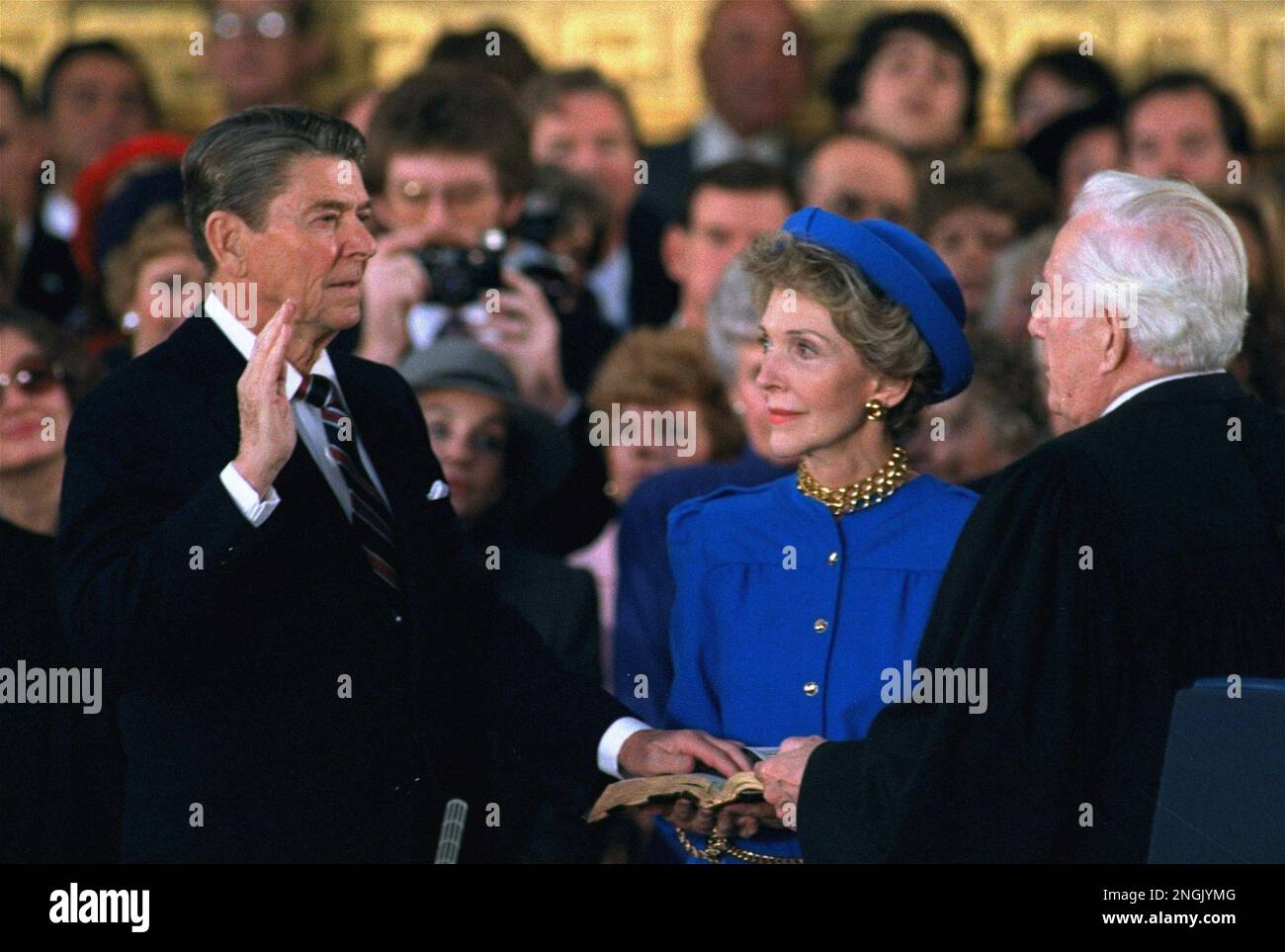 First Lady Nancy Reagan looks on as President Ronald Reagan is sworn in ...