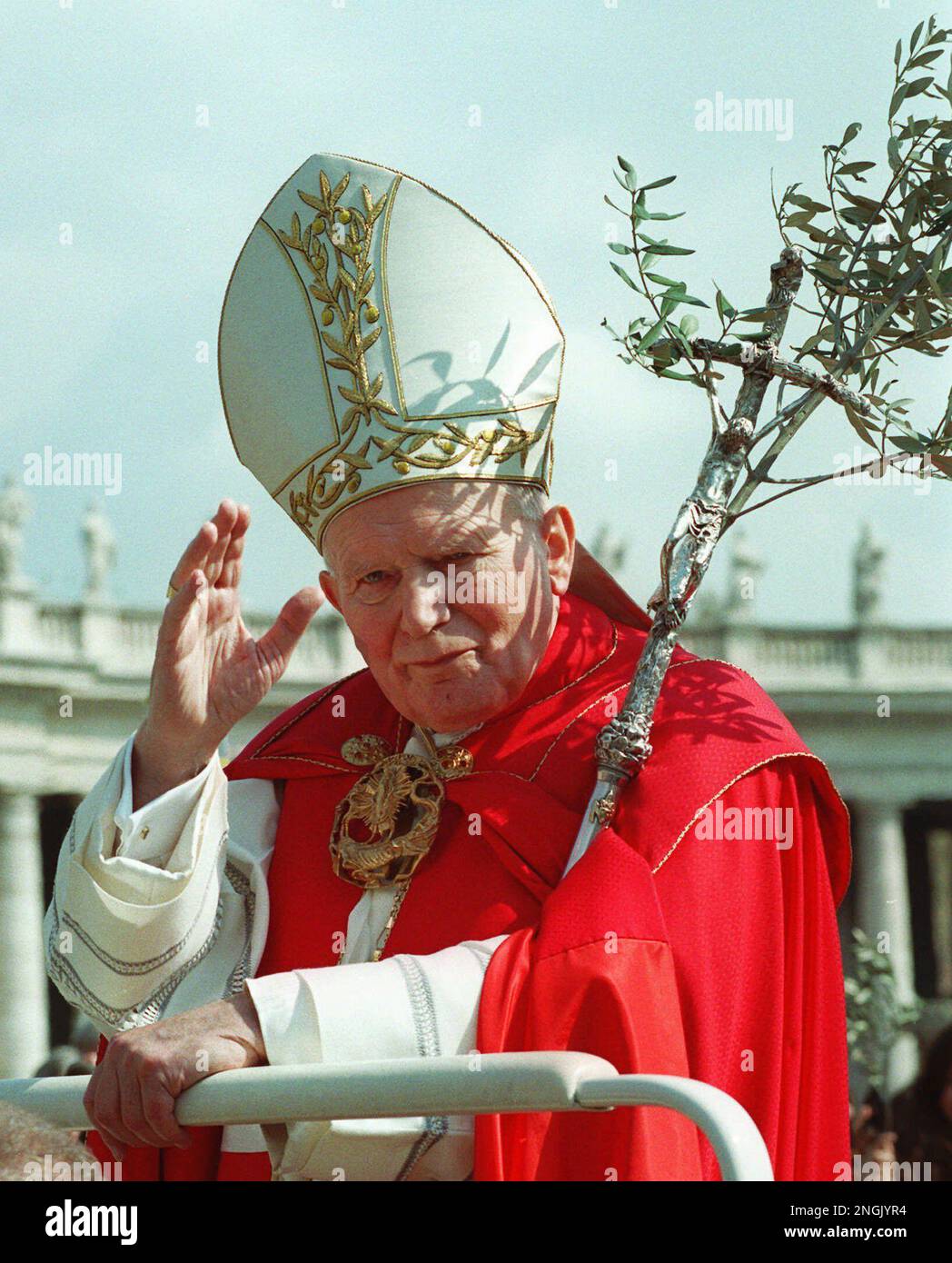 Pope John Paul II holds crucifix and a sprig of olive as he waves to ...