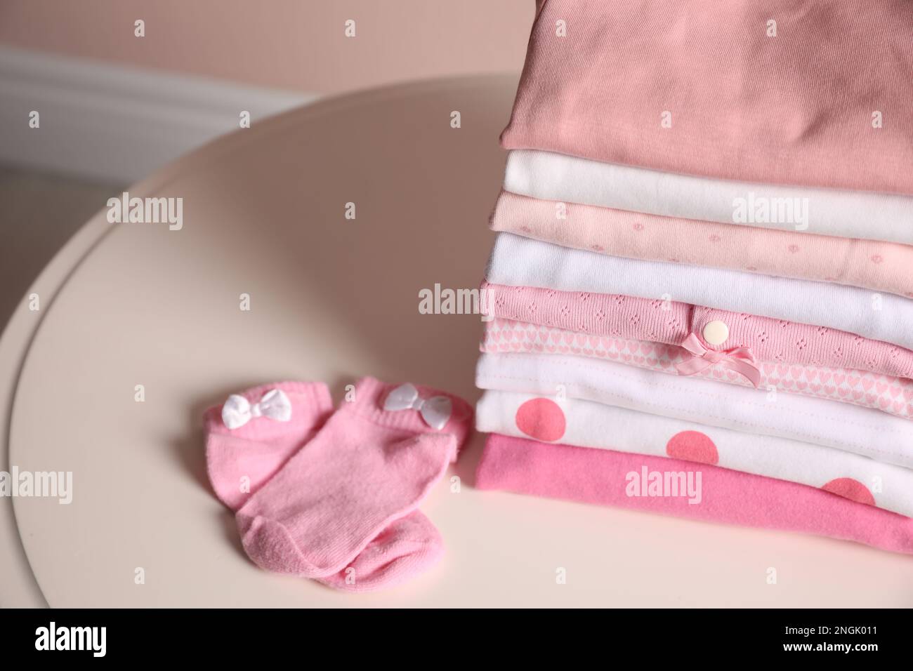 Stack of clean girl's clothes and socks on table Stock Photo - Alamy