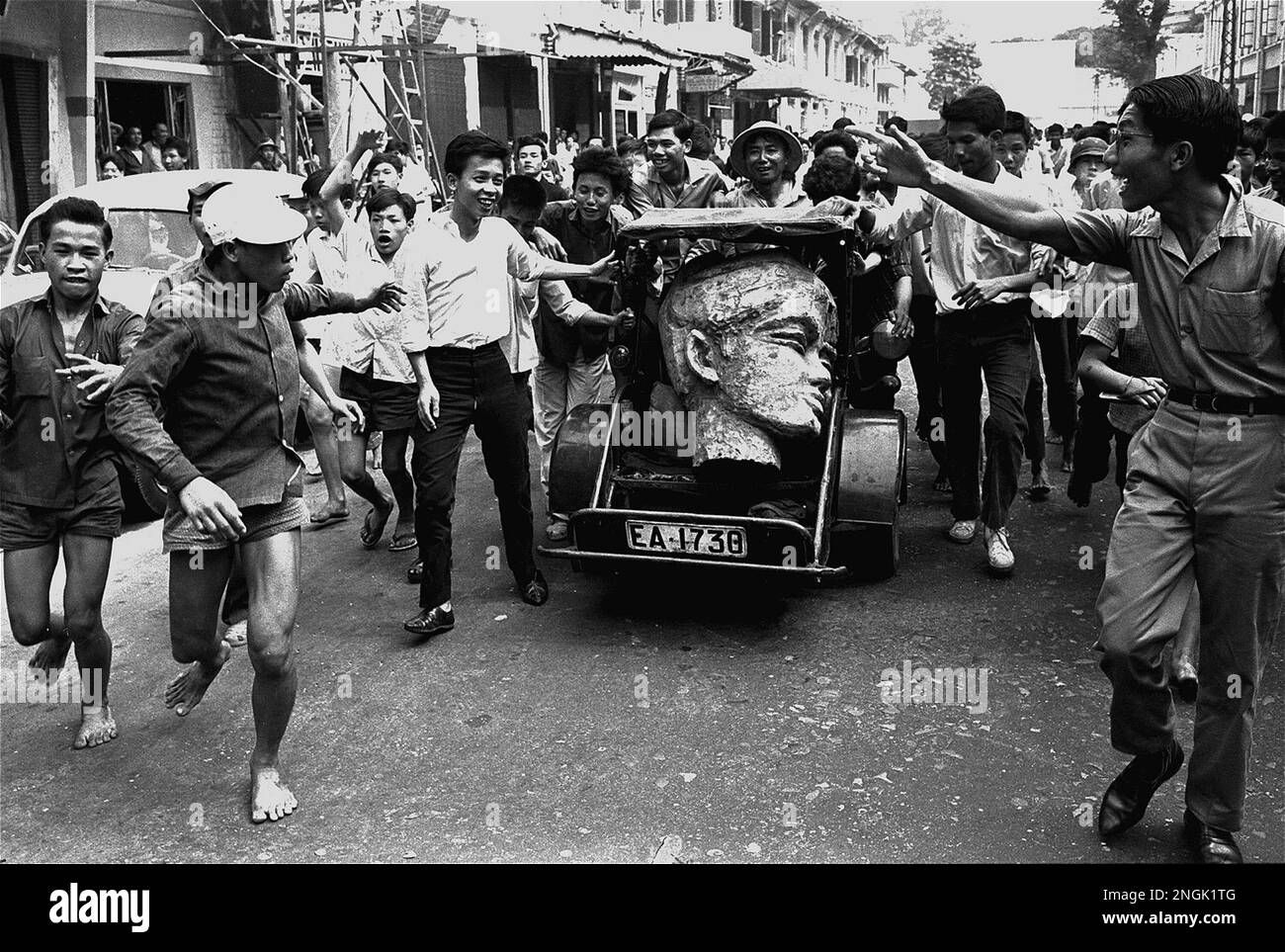 A Vietnamese crowd jeers as a peddicab driver carts the head of a ...