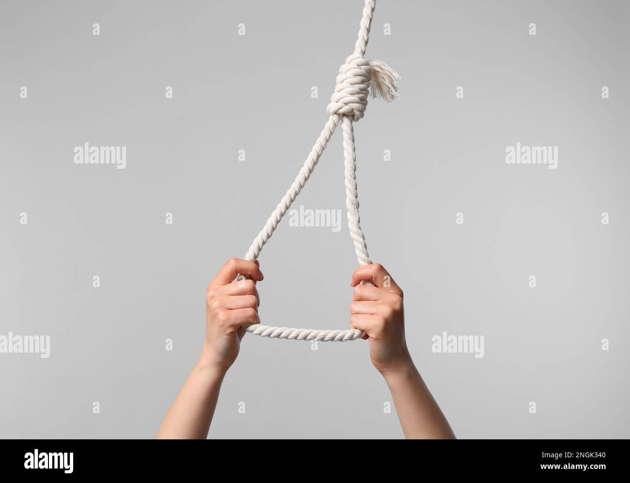 Woman holding rope noose on light grey background, closeup Stock Photo ...