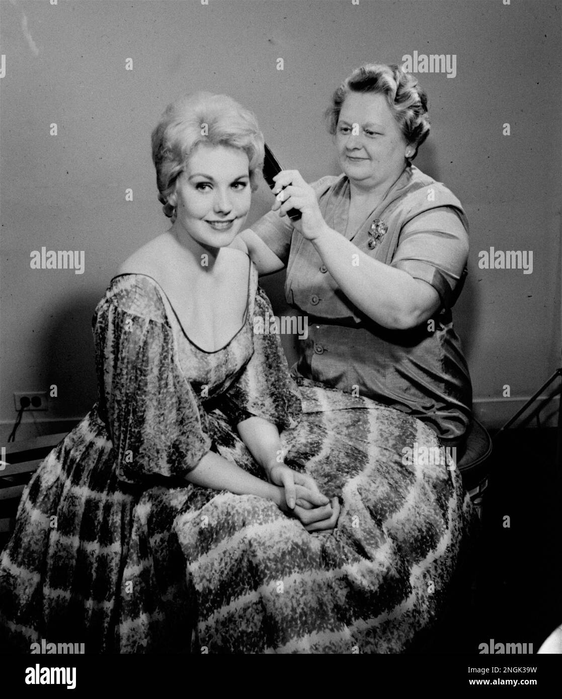 Actress Kim Novak's mother, Mrs. Joseph Novak, brushes her hair during ...