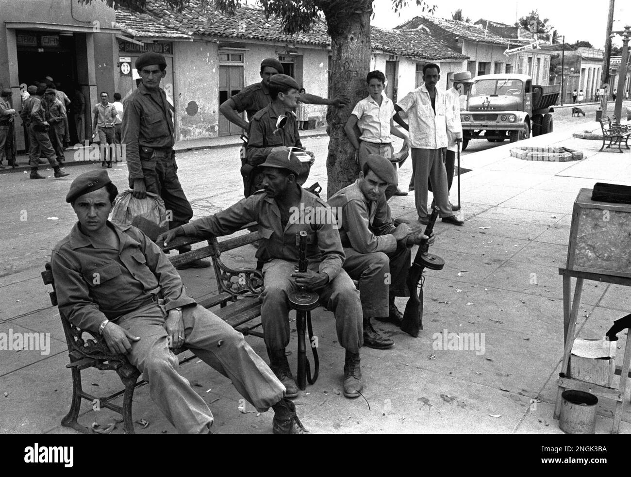 Cuban soldiers hold Russian-made tommy guns as they sit on a bench in ...