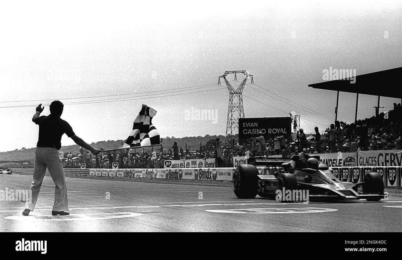 Mario Andretti, in a JPS-Lotus gets the checkered flag as he crosses ...