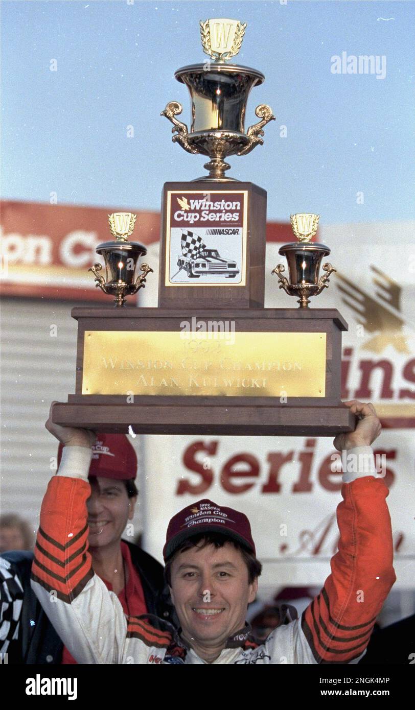 NASCAR driver Alan Kulwicki holds the Winston Cup Championship trophy ...