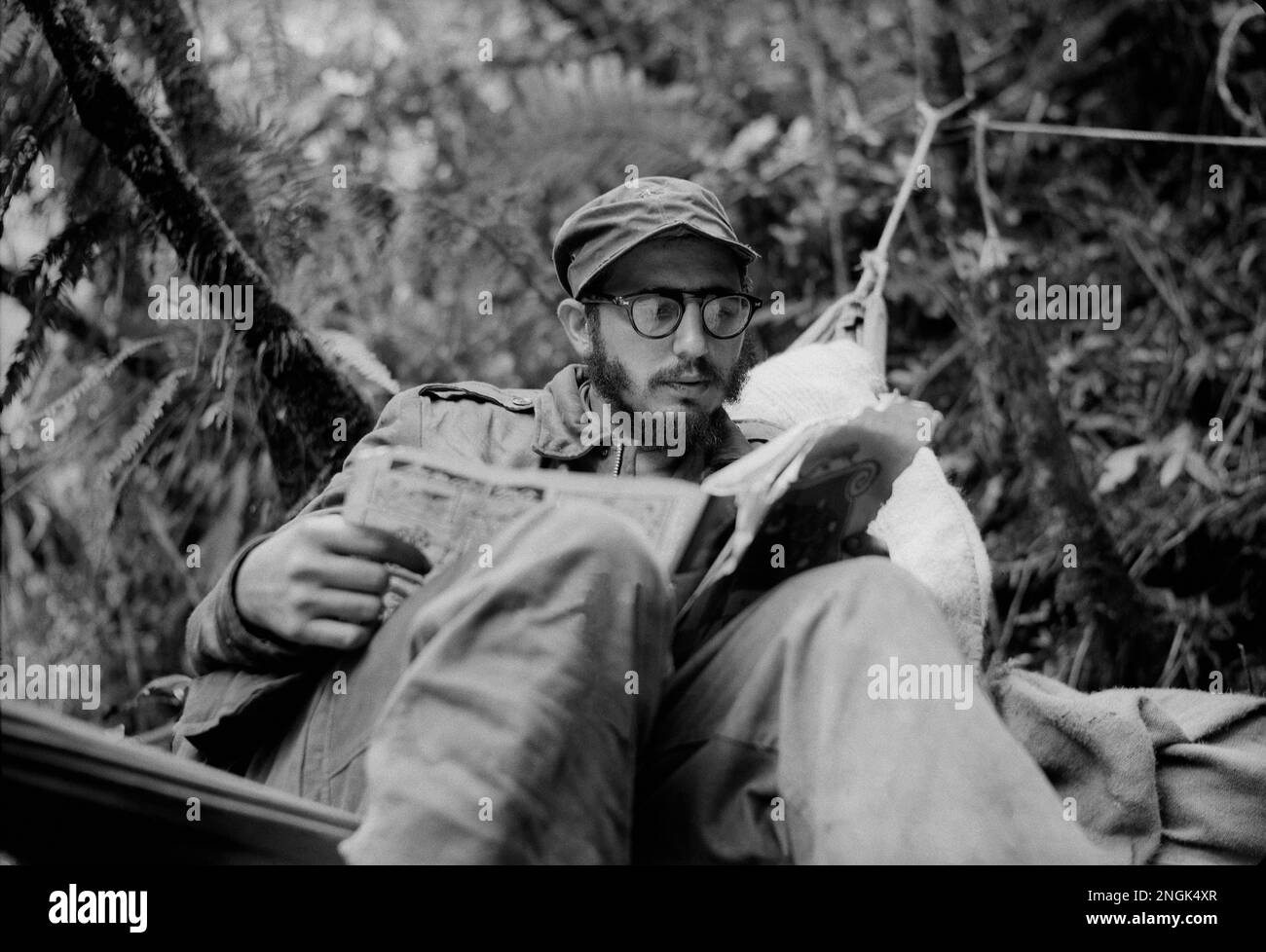 Cuban guerrilla leader Fidel Castro does some reading while at his ...