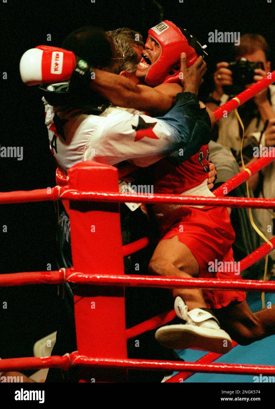 Boxer David Reid is embraced by head coach Al Mitchell, left, and ...
