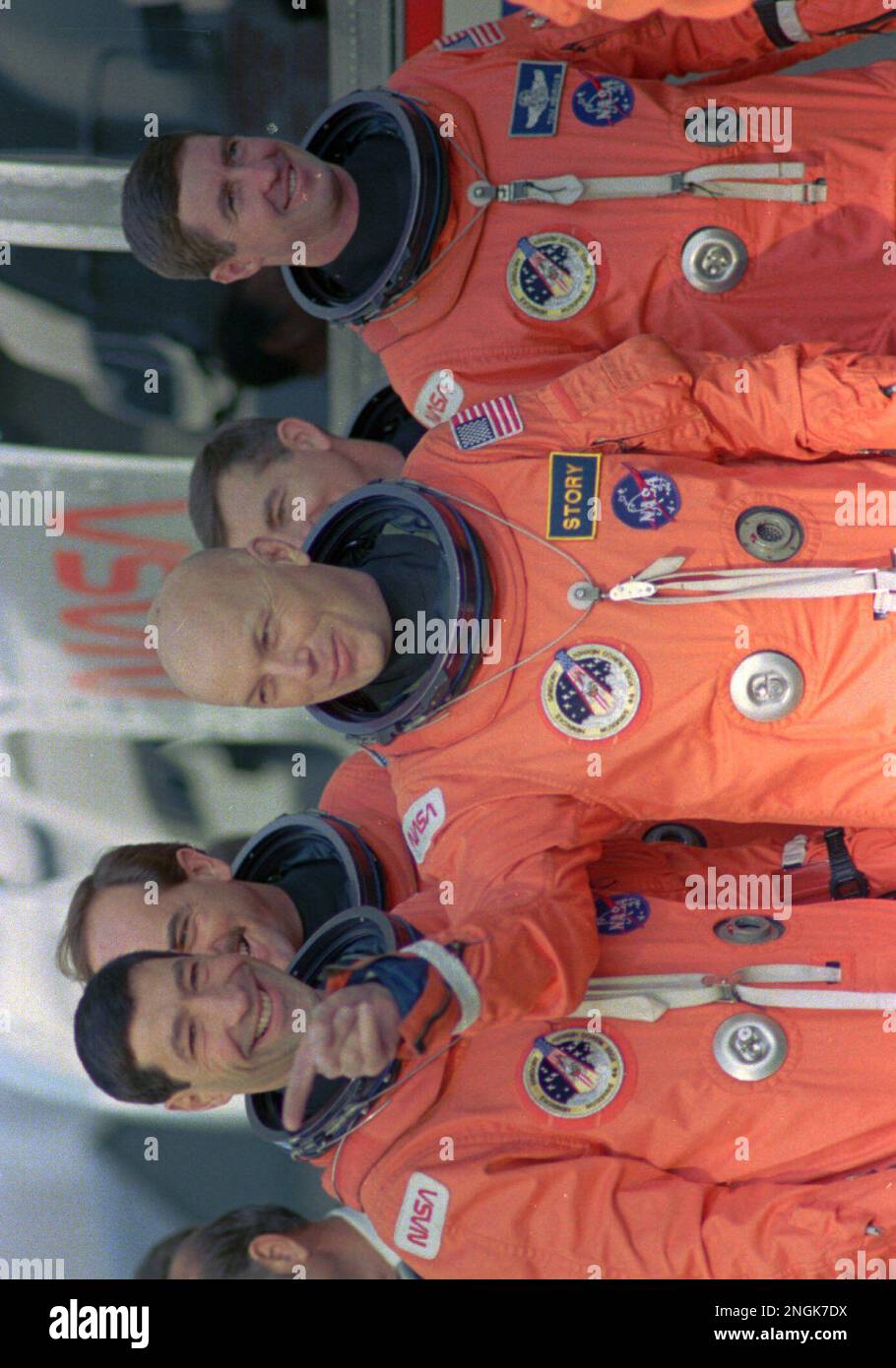 STS-44 Mission Specialist Story Musgrave, center, points his finger at ...
