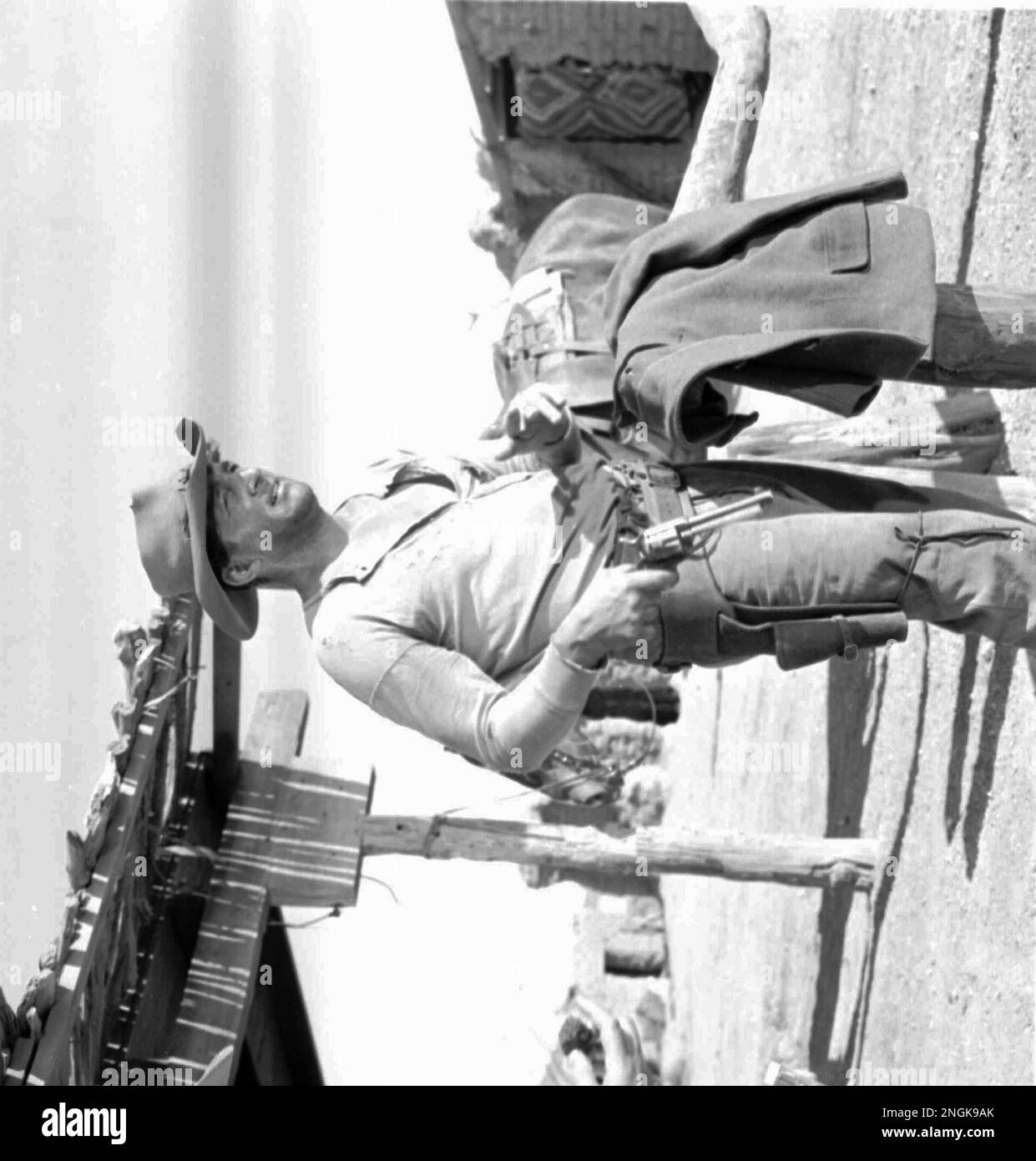 Dean Martin draws his gun on the set of "Rio Bravo," in which he plays ...