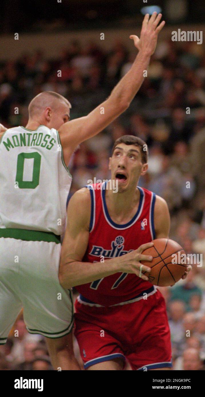 Washington Bullets center Gheorghe Muresan (77) takes the ball to the ...