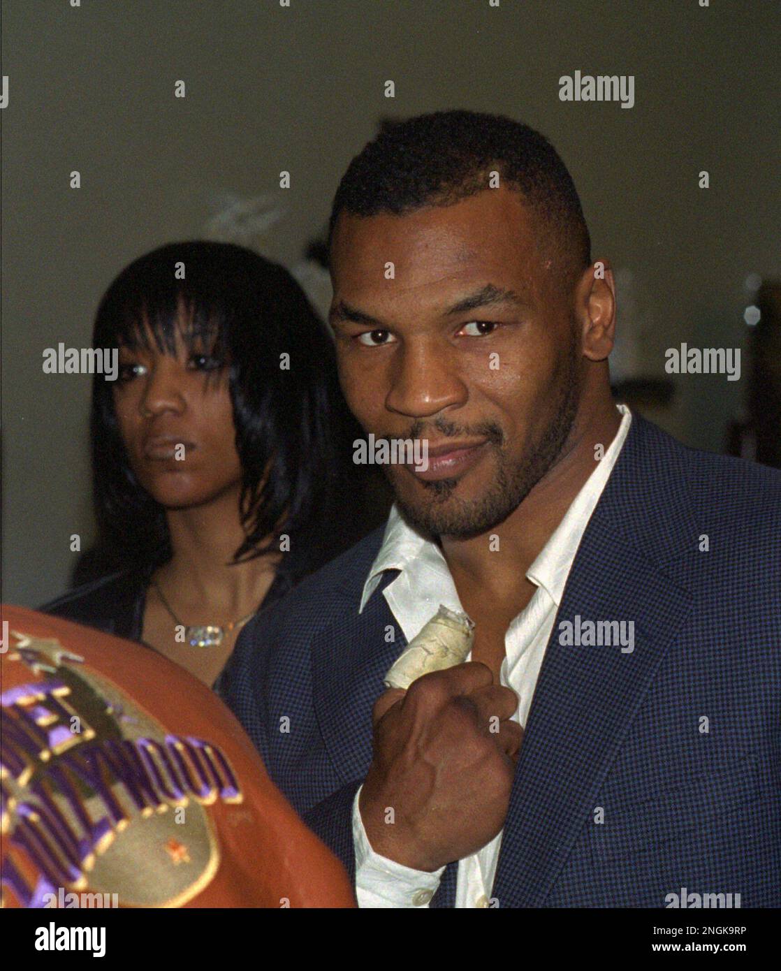 Mike Tyson makes a fist as boxing fans watch him shop in Gianni Versace ...