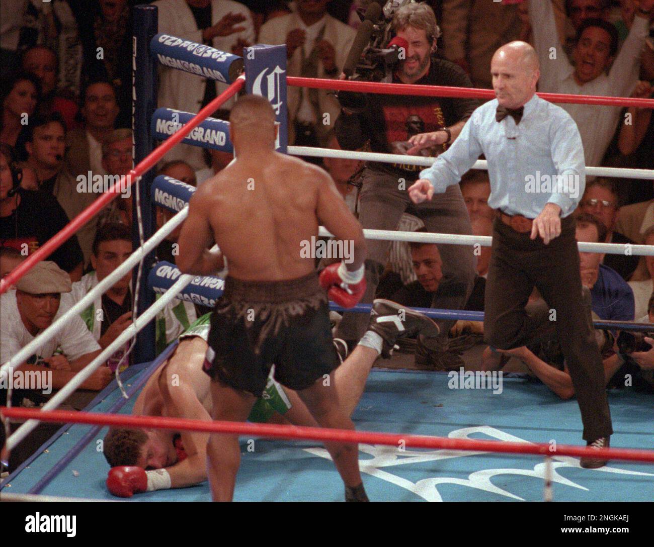 Mike Tyson stands over Peter McNeeley as referee Mills Lane just before ...