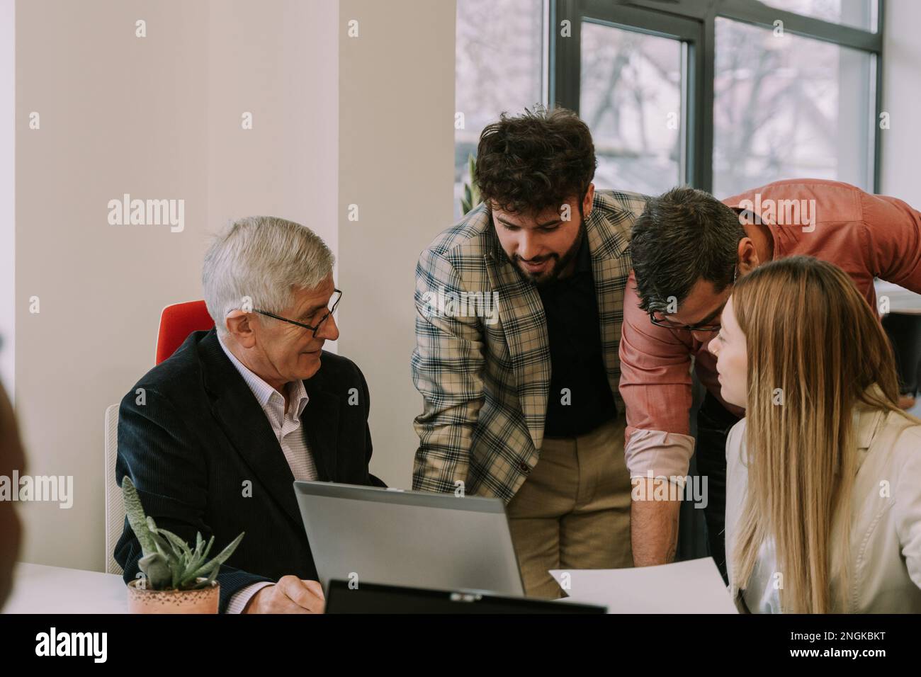 A kind handsome businessman teaching his coworkers at the very best way ...