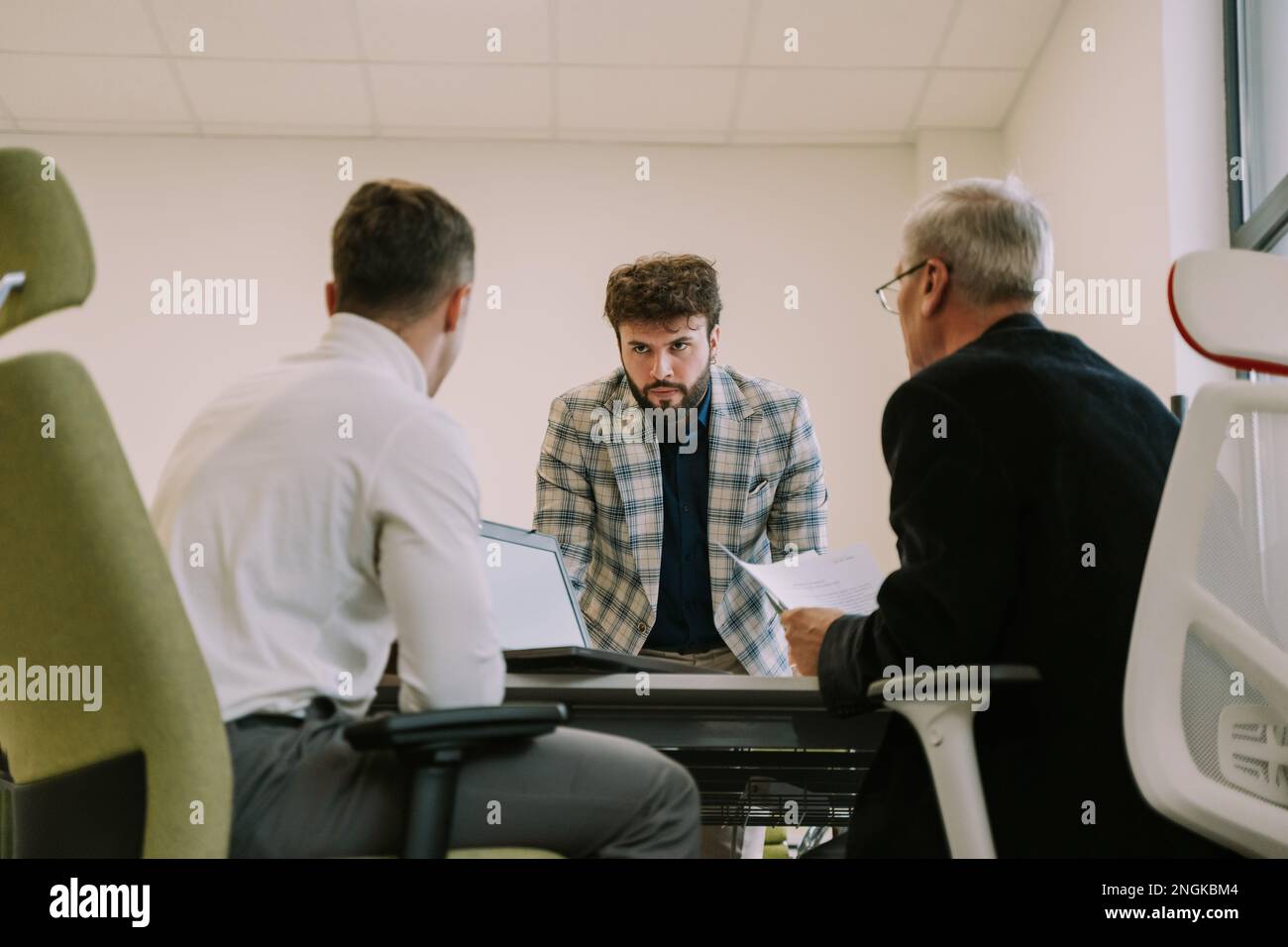 Disappointed and angry boss overlooking his employees at the office ...