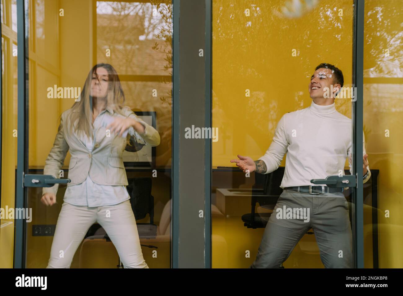 Two business colleagues goofing off and dancing in the phone booths at ...