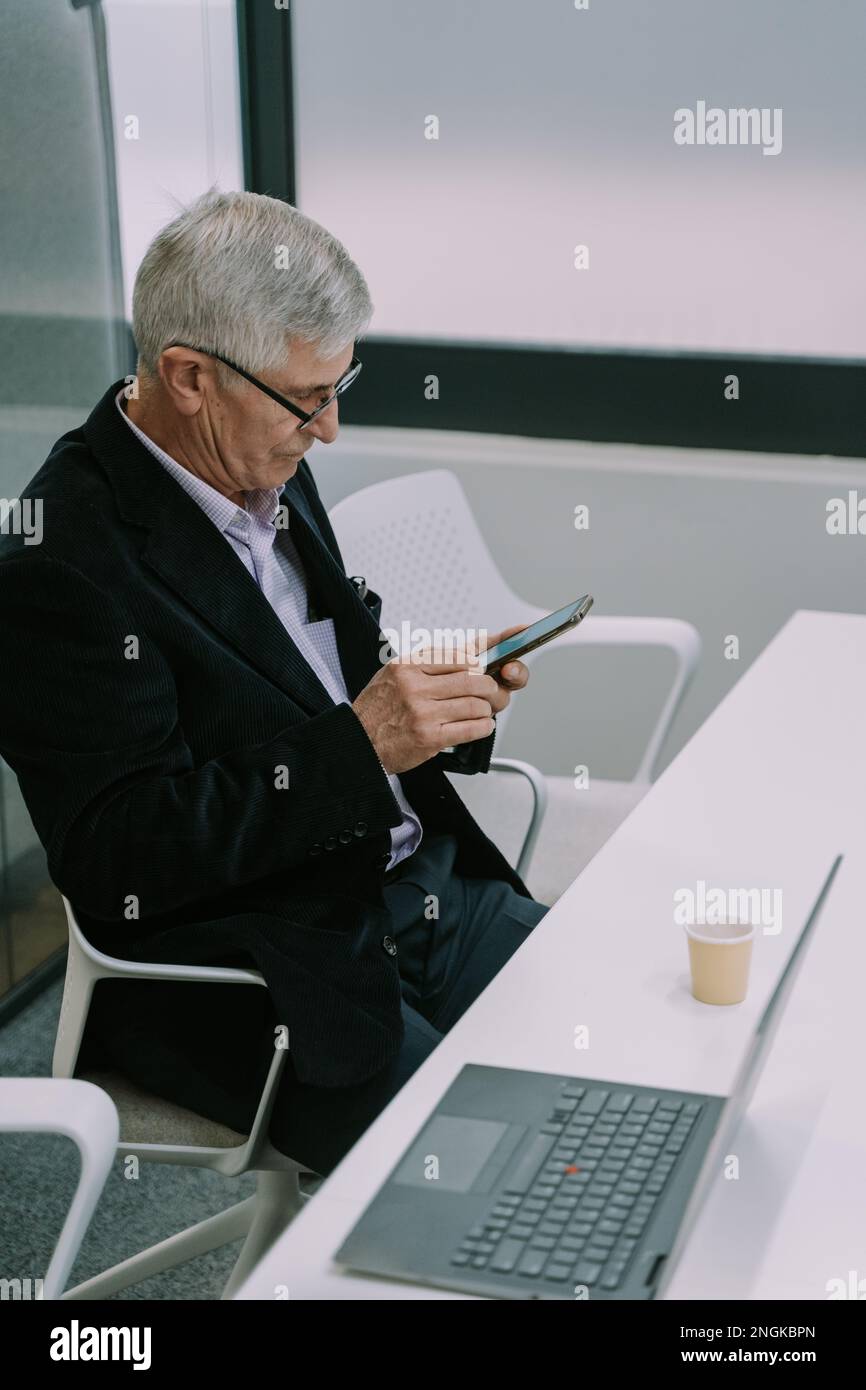 A handsome senior businessman checking his mail at work early in the ...