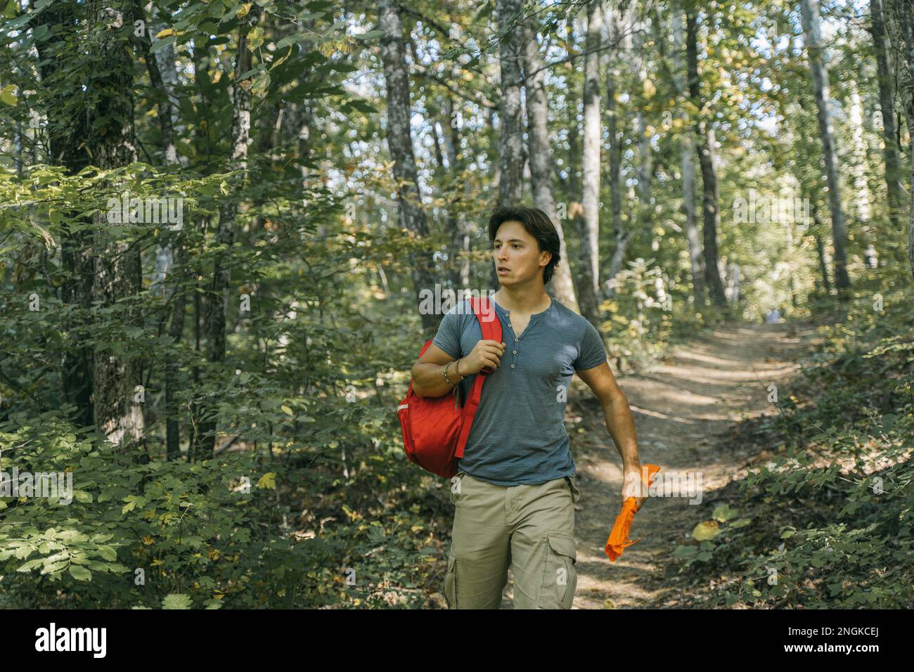 Strong man, hiker, walking and starring at some spot in the forest. He ...