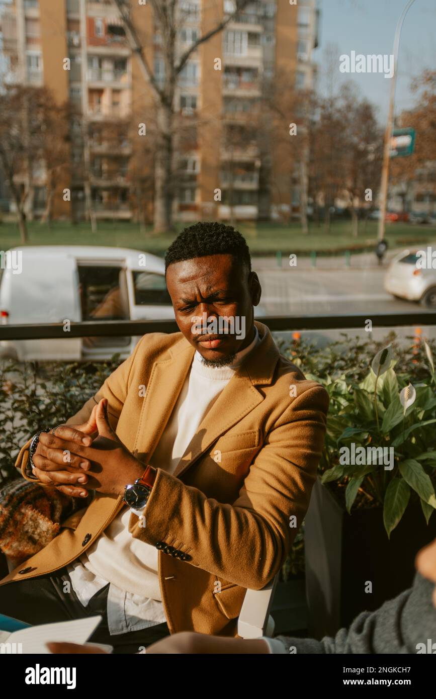 Handsome black business man making angry faces while sitting at the ...