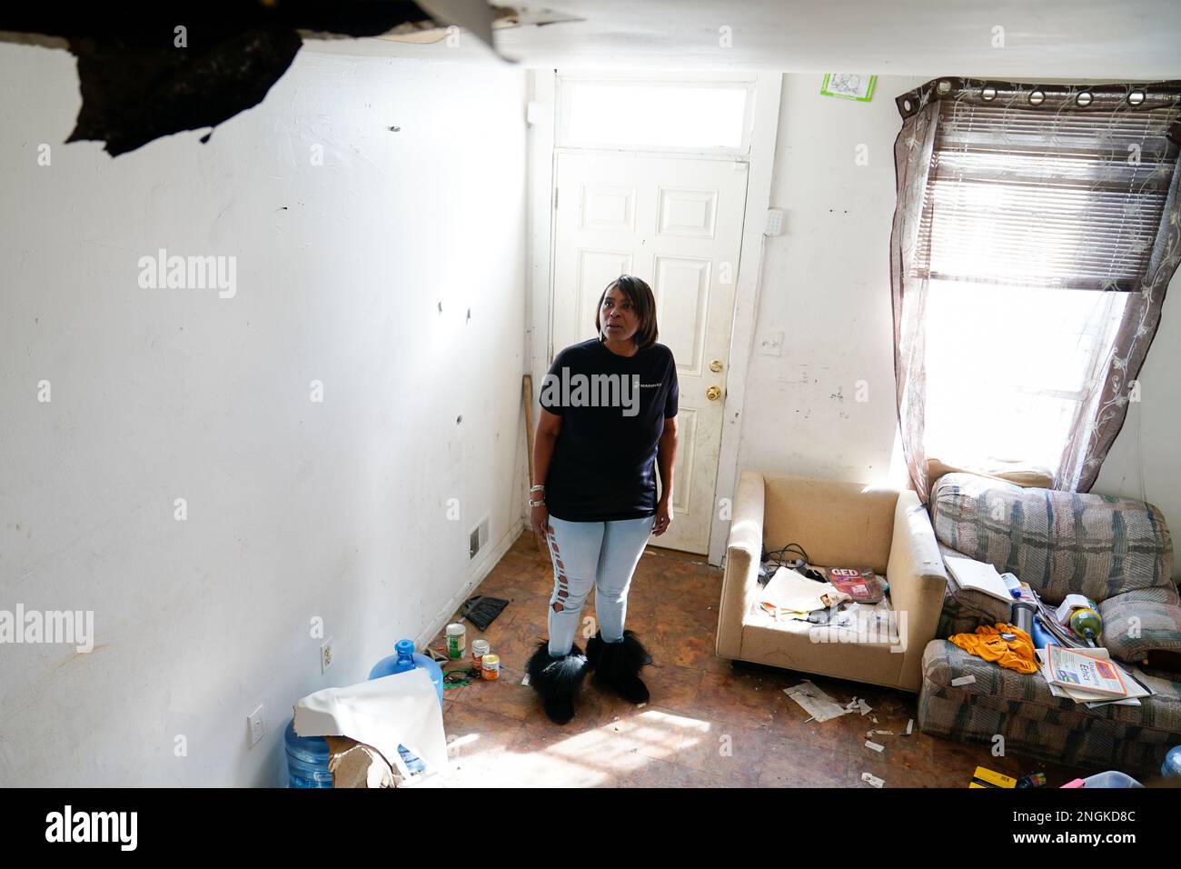 Angela Banks looks through the unkept living room of the house she used ...