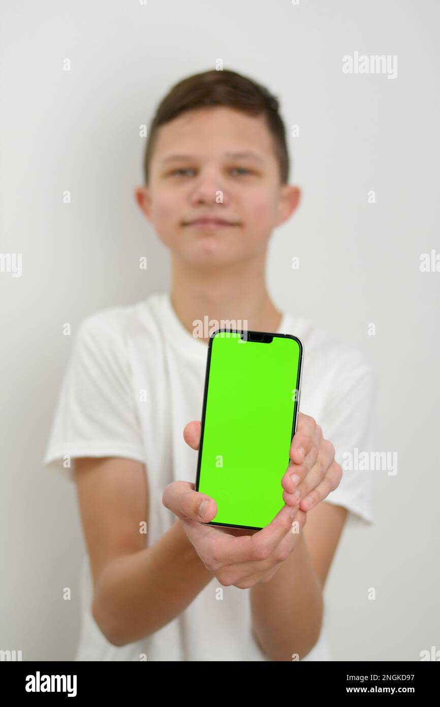 Wow excited young Asian man showing mobile phone with open hand gesture ...