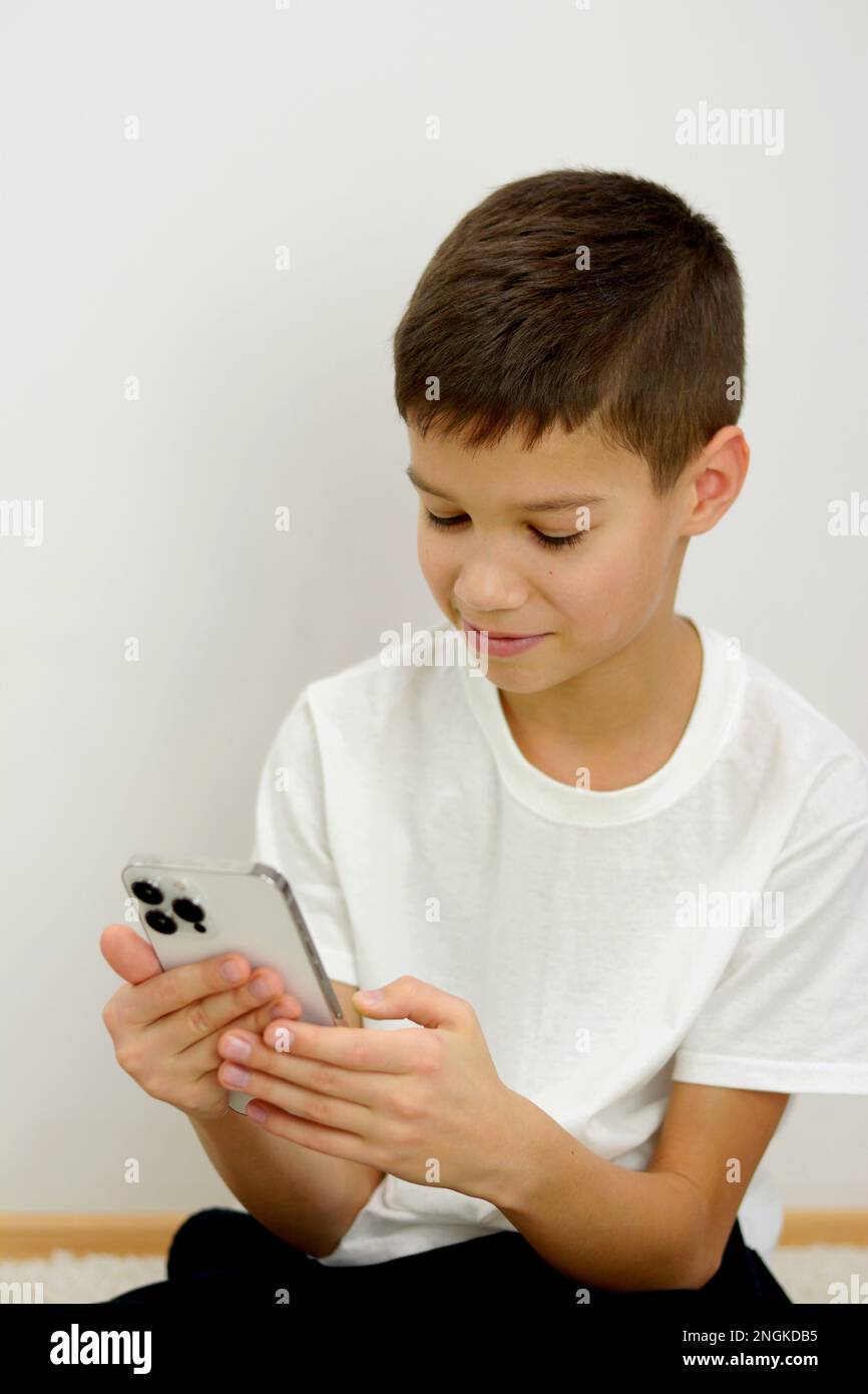 Back to school. Cute child with backpack, holding mobile phone, playing ...