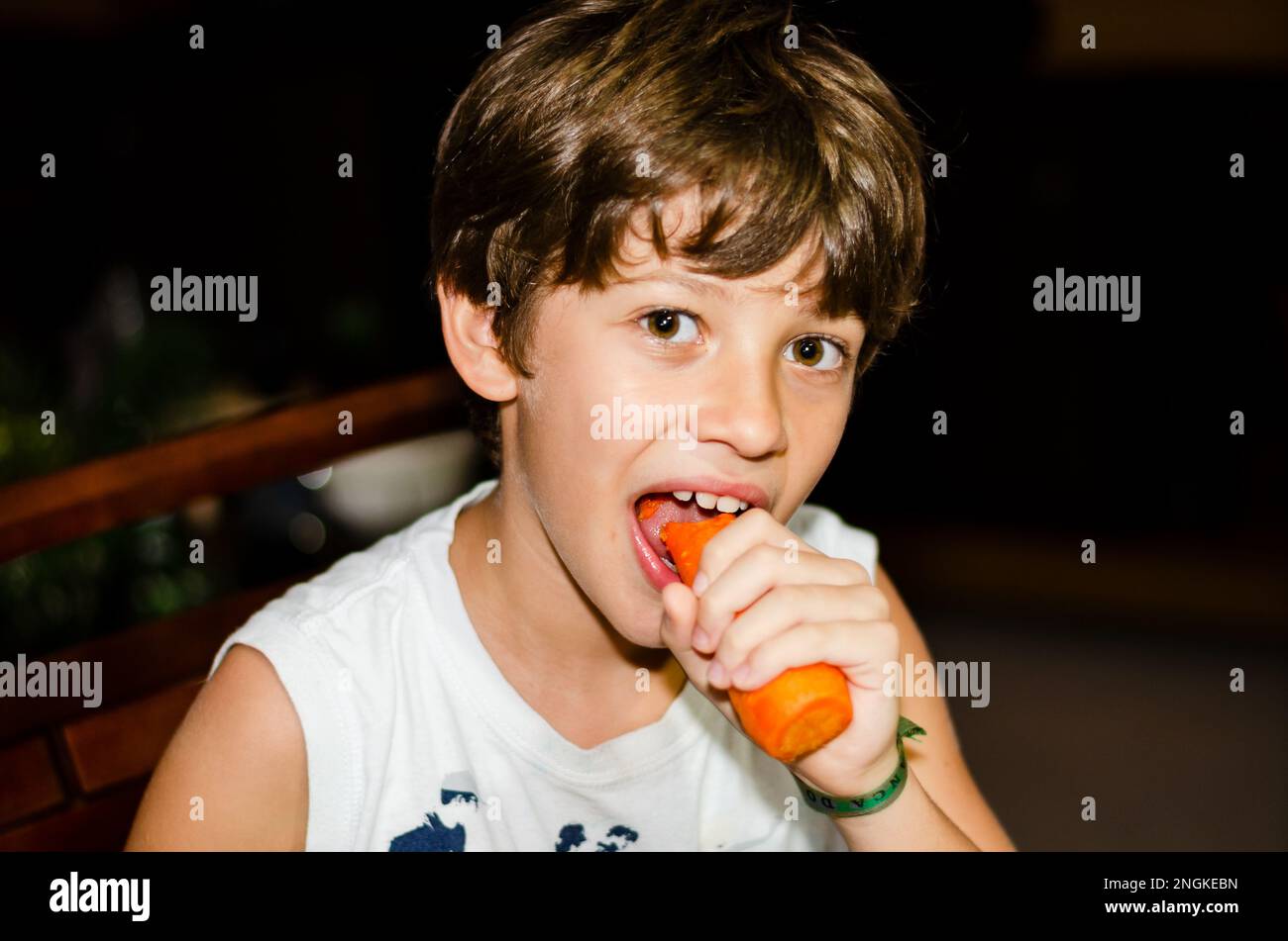 Cute boy biting a carrot. Health concept Stock Photo - Alamy