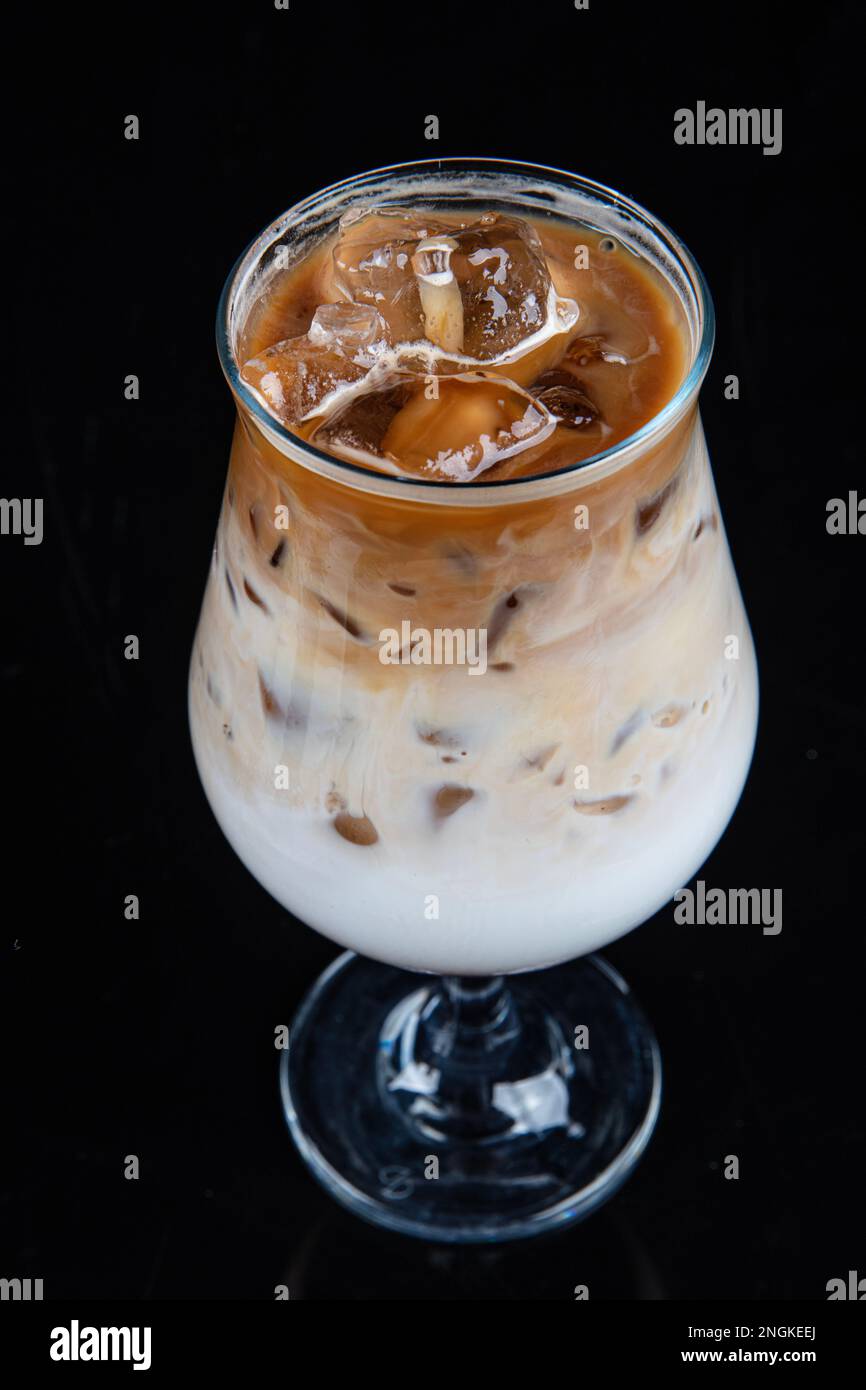 Iced coffee mug. Iced coffee is poured into a tall glass with cream ...