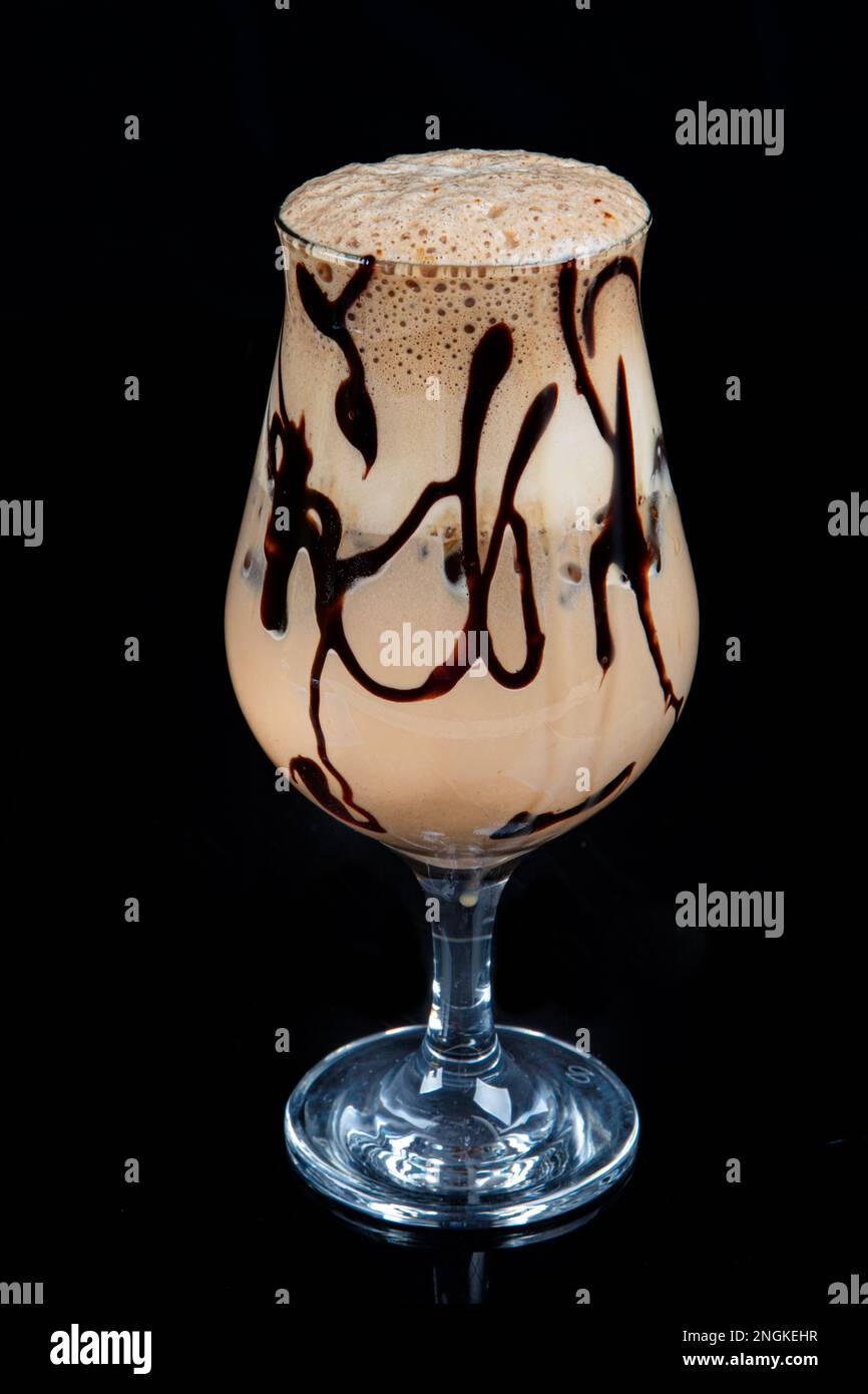 Iced coffee mug. Iced coffee is poured into a tall glass with cream ...