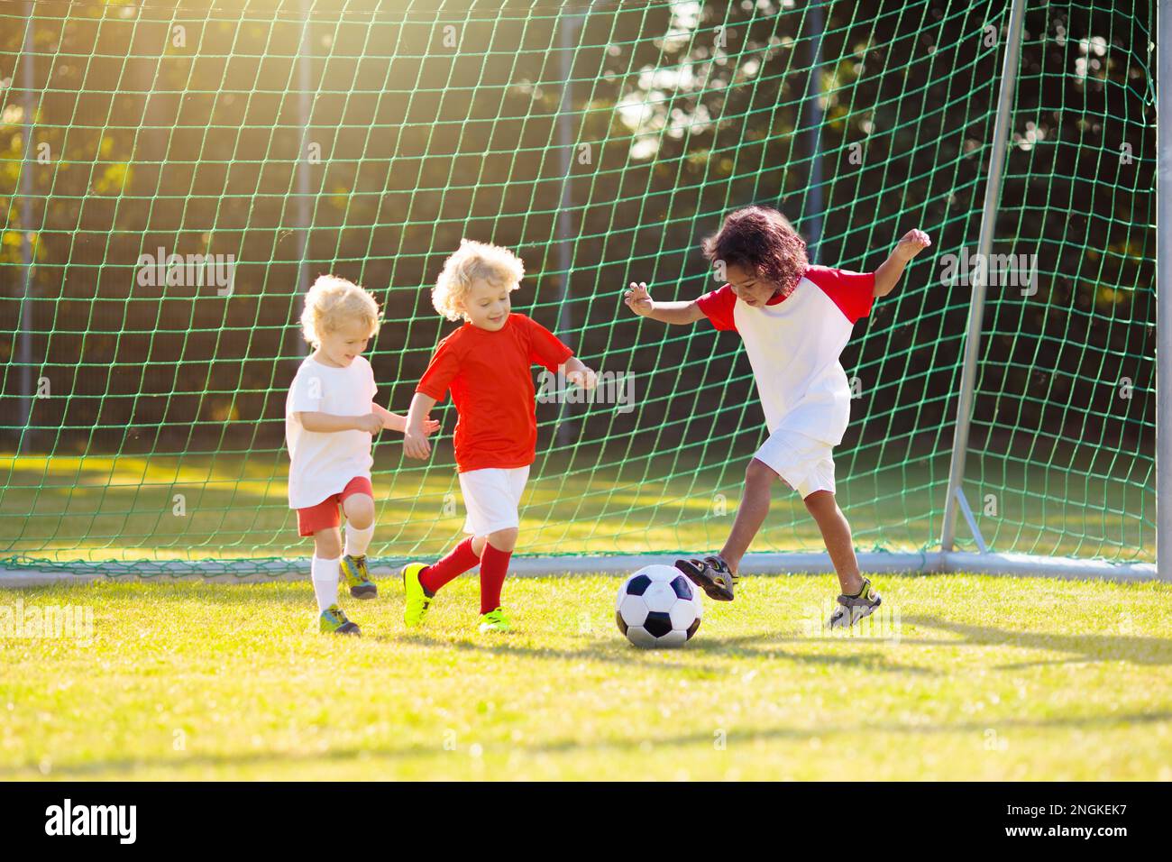 Kids play football. Cute little boy playing football. Children run on ...