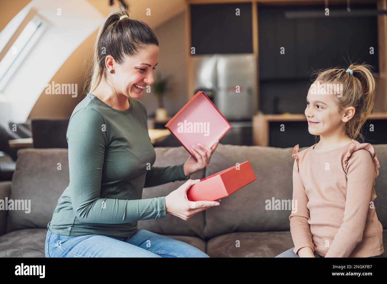 Happy mother is getting gift from her daughter Stock Photo - Alamy