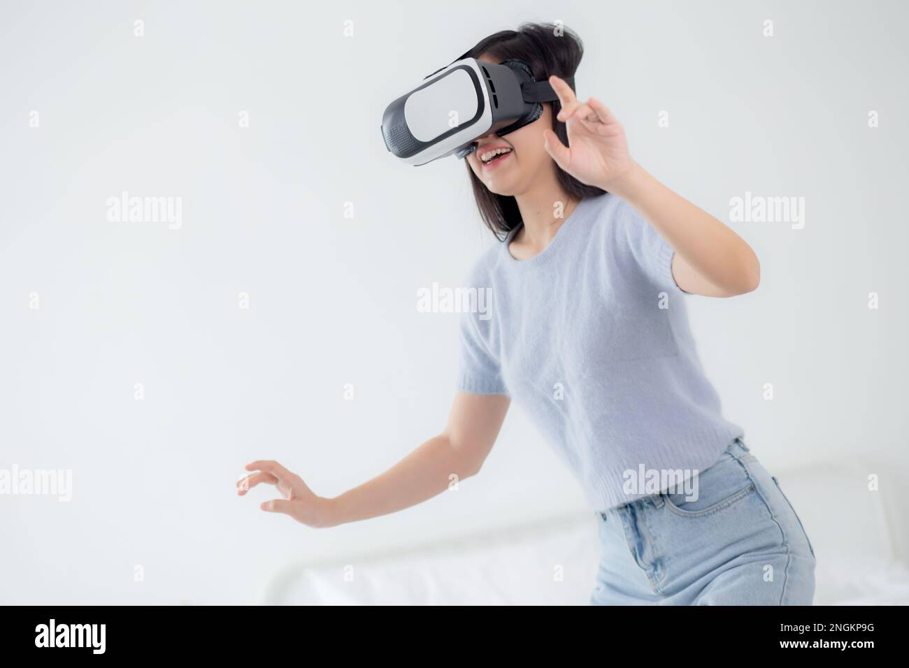 Young asian woman wearing vr headset playing game with excited in the ...