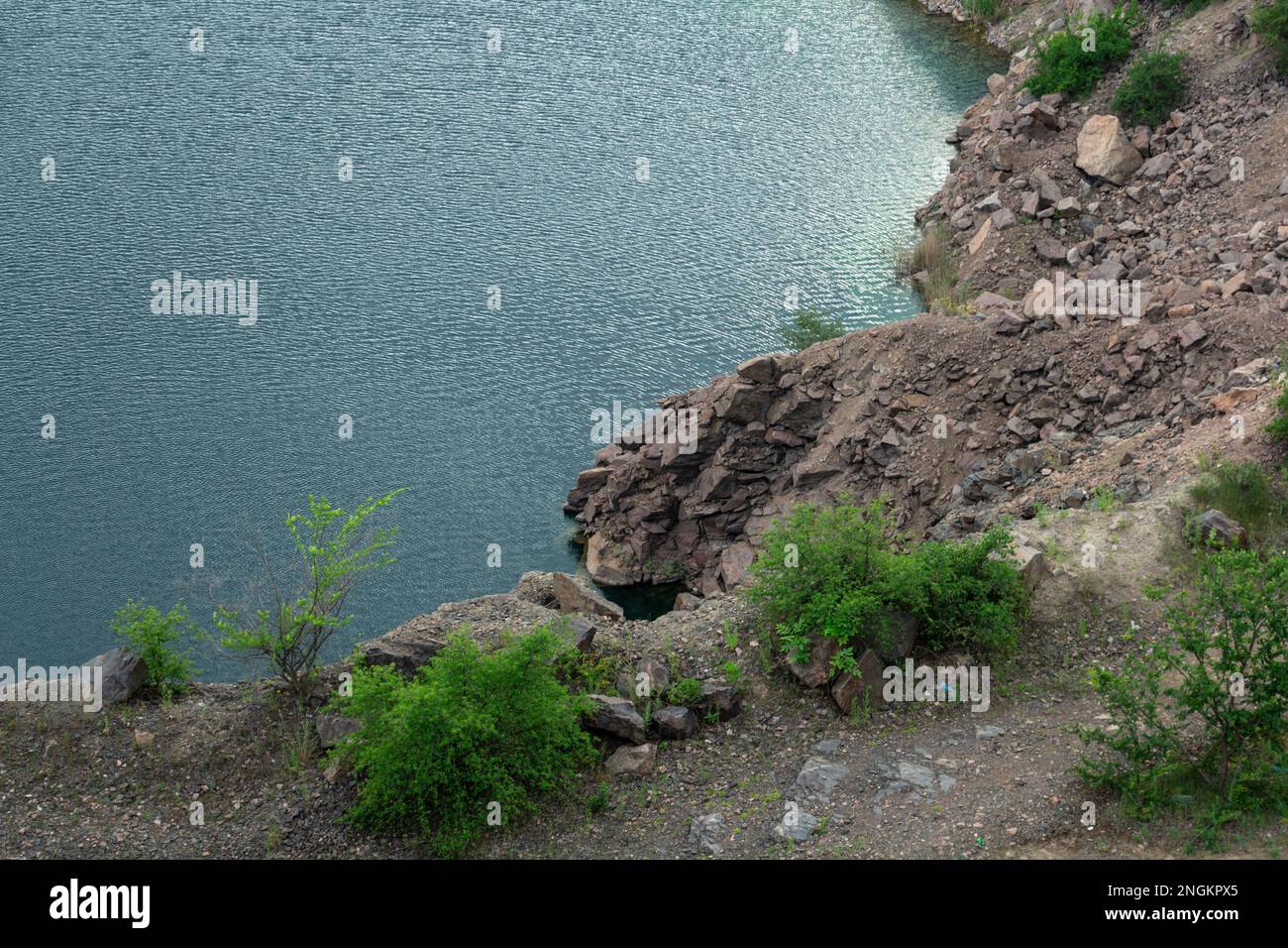 rocky cliff and lake with dark blue water, quarry lakes Stock Photo - Alamy