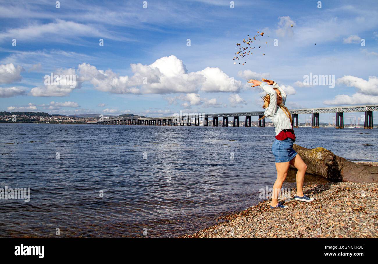 Woman throwing pebbles in water hi-res stock photography and images - Alamy