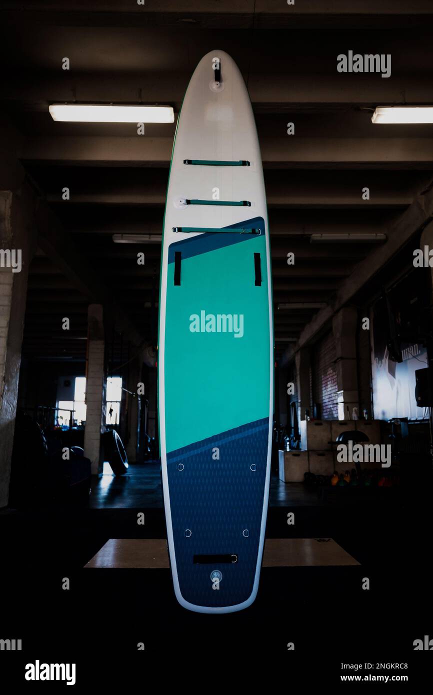 Colorful inflatable stand-up paddle board SUP by the wall. Surfing and ...