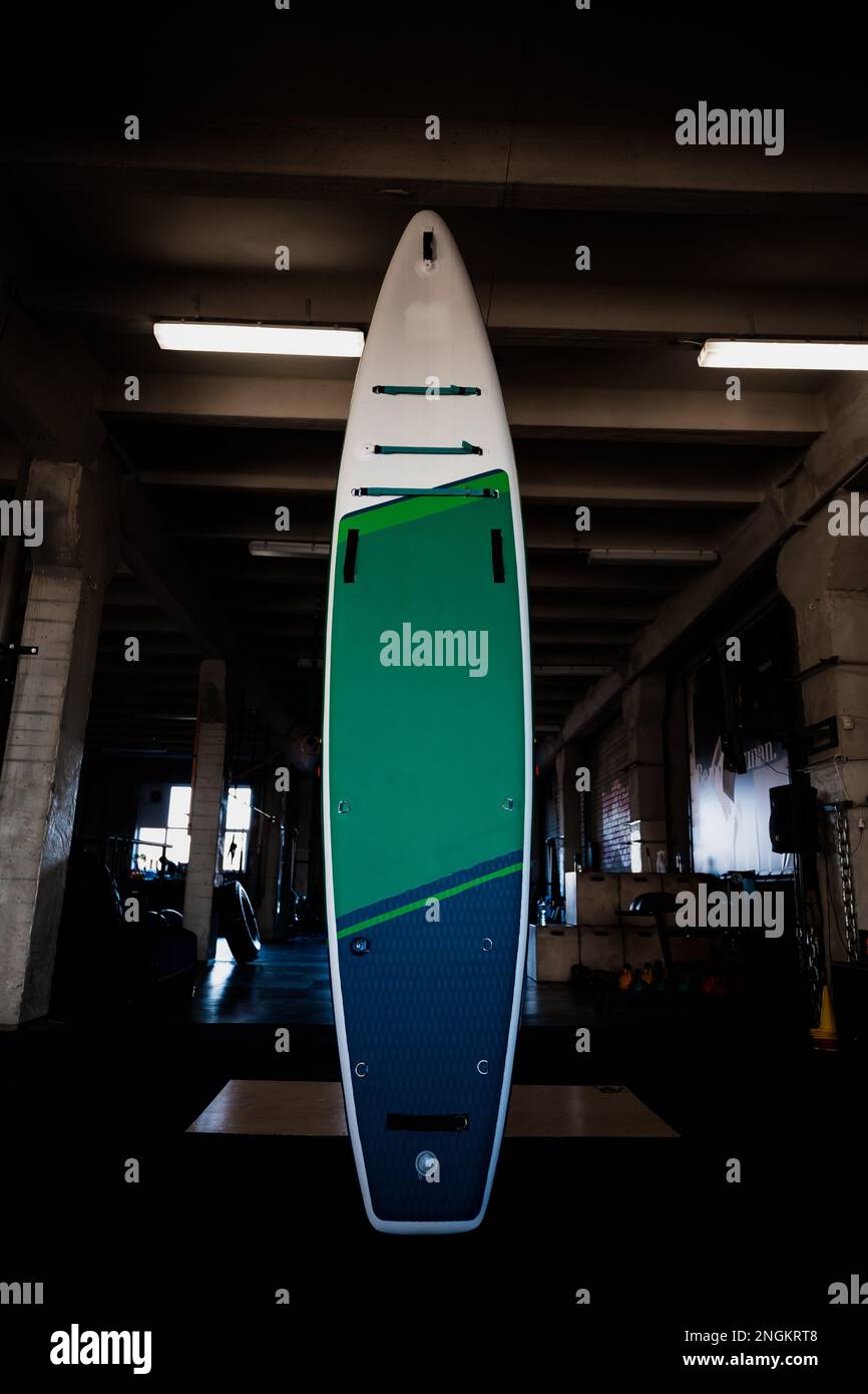 Colorful inflatable stand-up paddle board SUP by the wall. Surfing and ...
