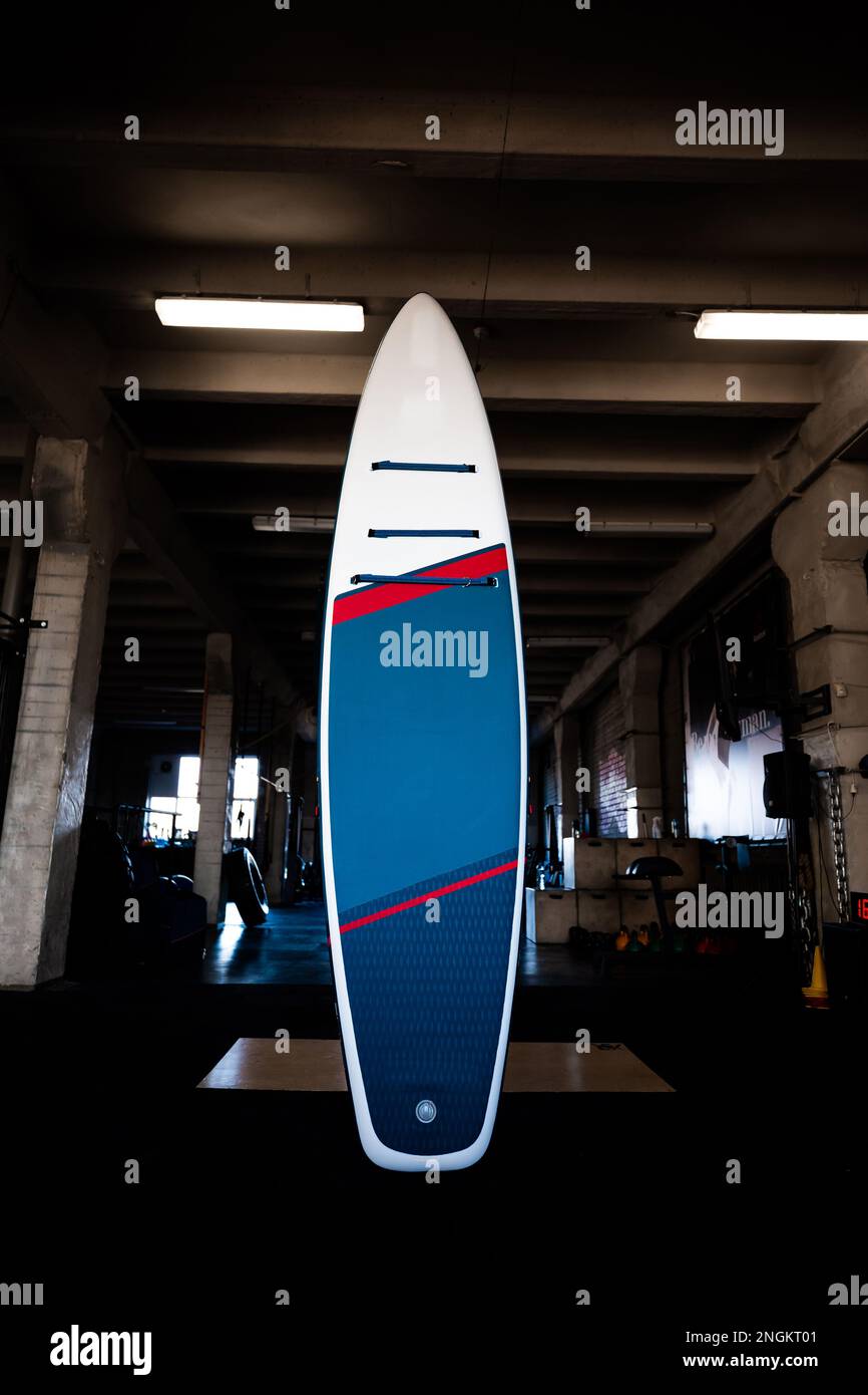 Blue inflatable stand-up paddle board SUP by the wall. Surfing and sup ...