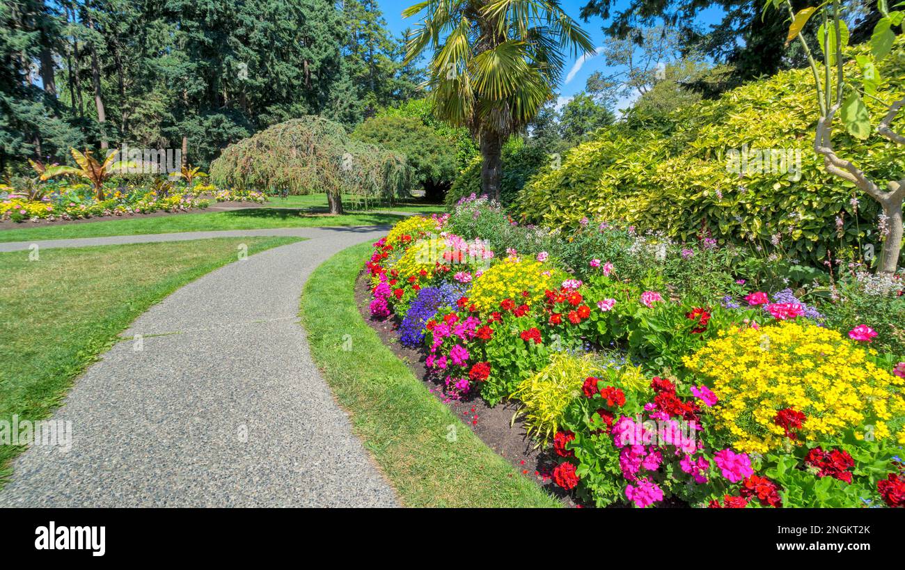 Green wide open meadow in a park with paved pathway Stock Photo - Alamy