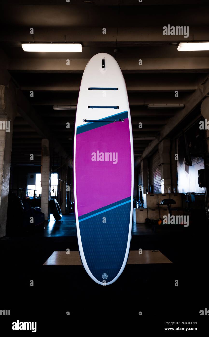 Pink inflatable stand-up paddle board SUP by the wall. Surfing and sup ...