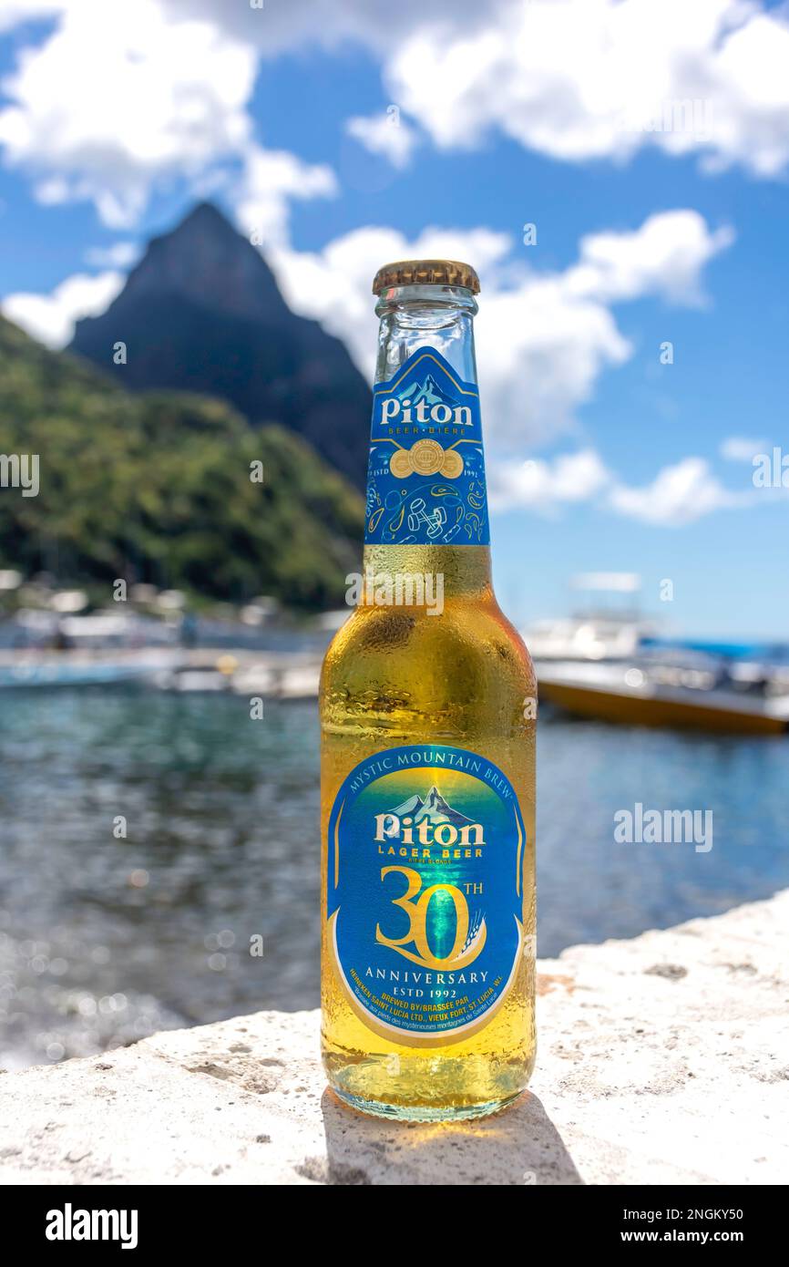 Bottle of Piton lager beer with The Pitions behind, Soufrière ...