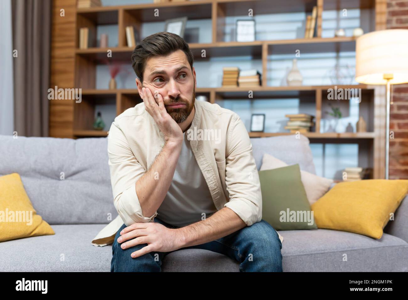 Overworked sad man sitting alone on sofa, mature businessman at home ...